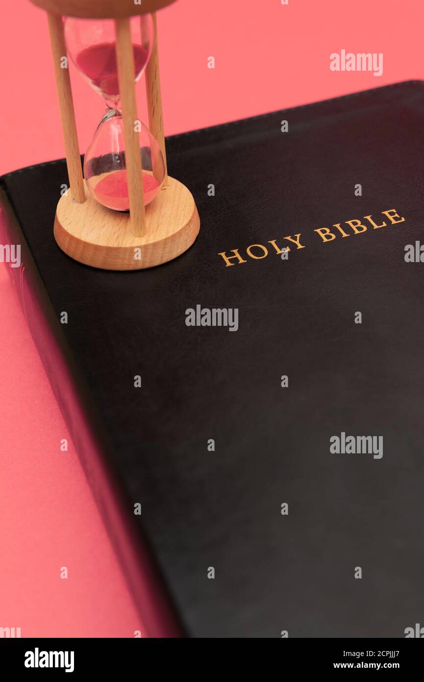 Holy Bible, the Word of God with hourglass. Isolated on red background ...