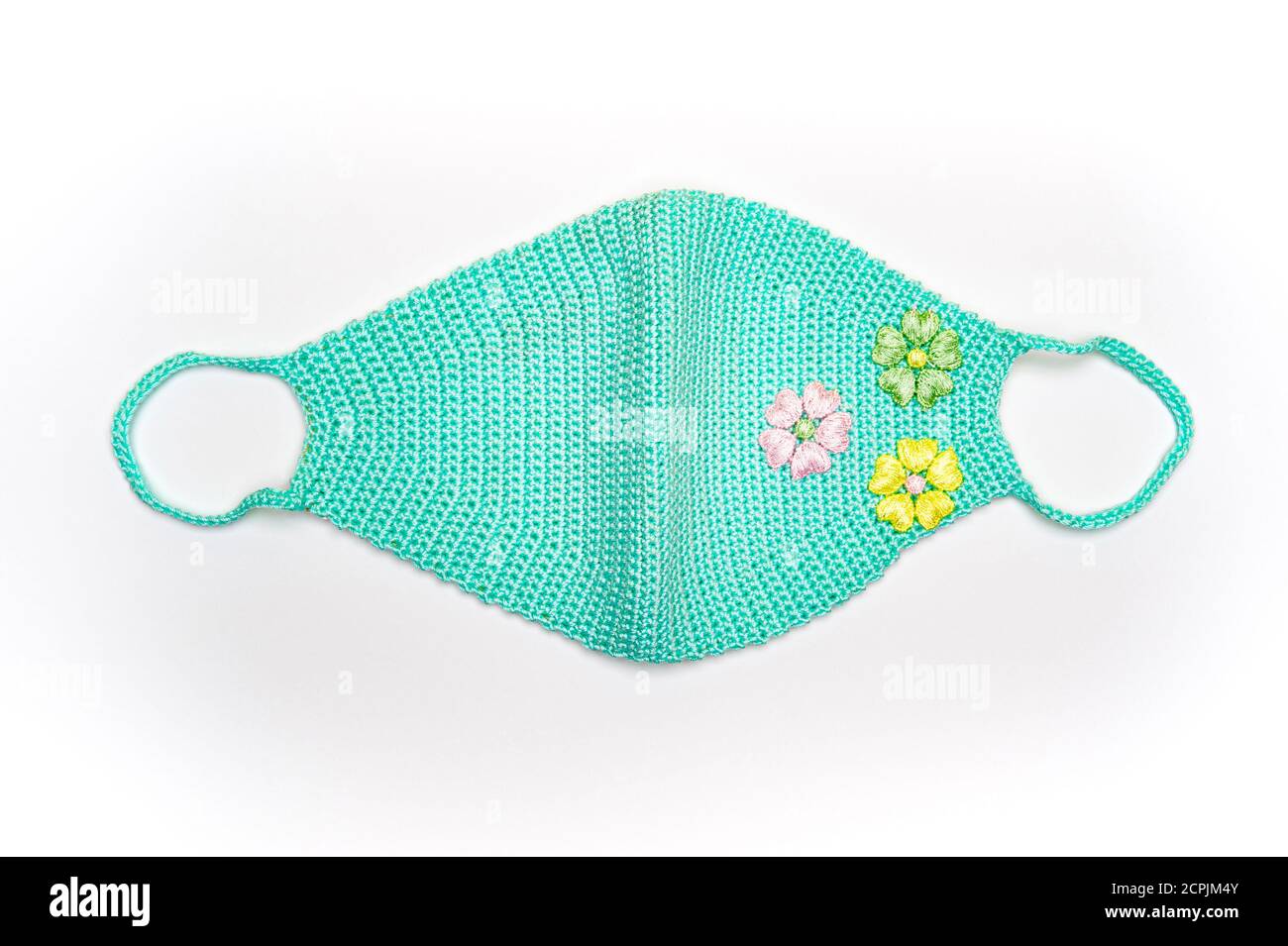 Homemade crochet face mask. Green color with flower designs. Isolated ...