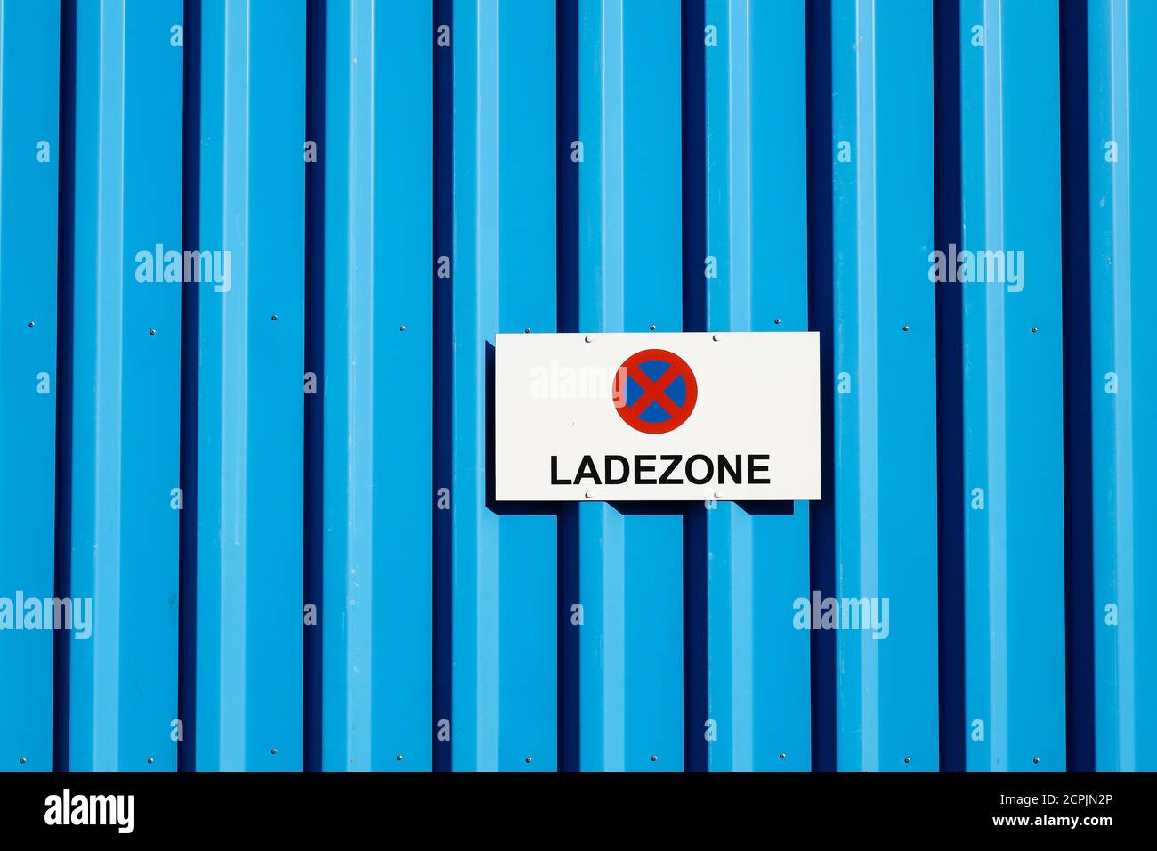 Sign loading zone on a blue wall of a commercial hall in the Osthafen ...