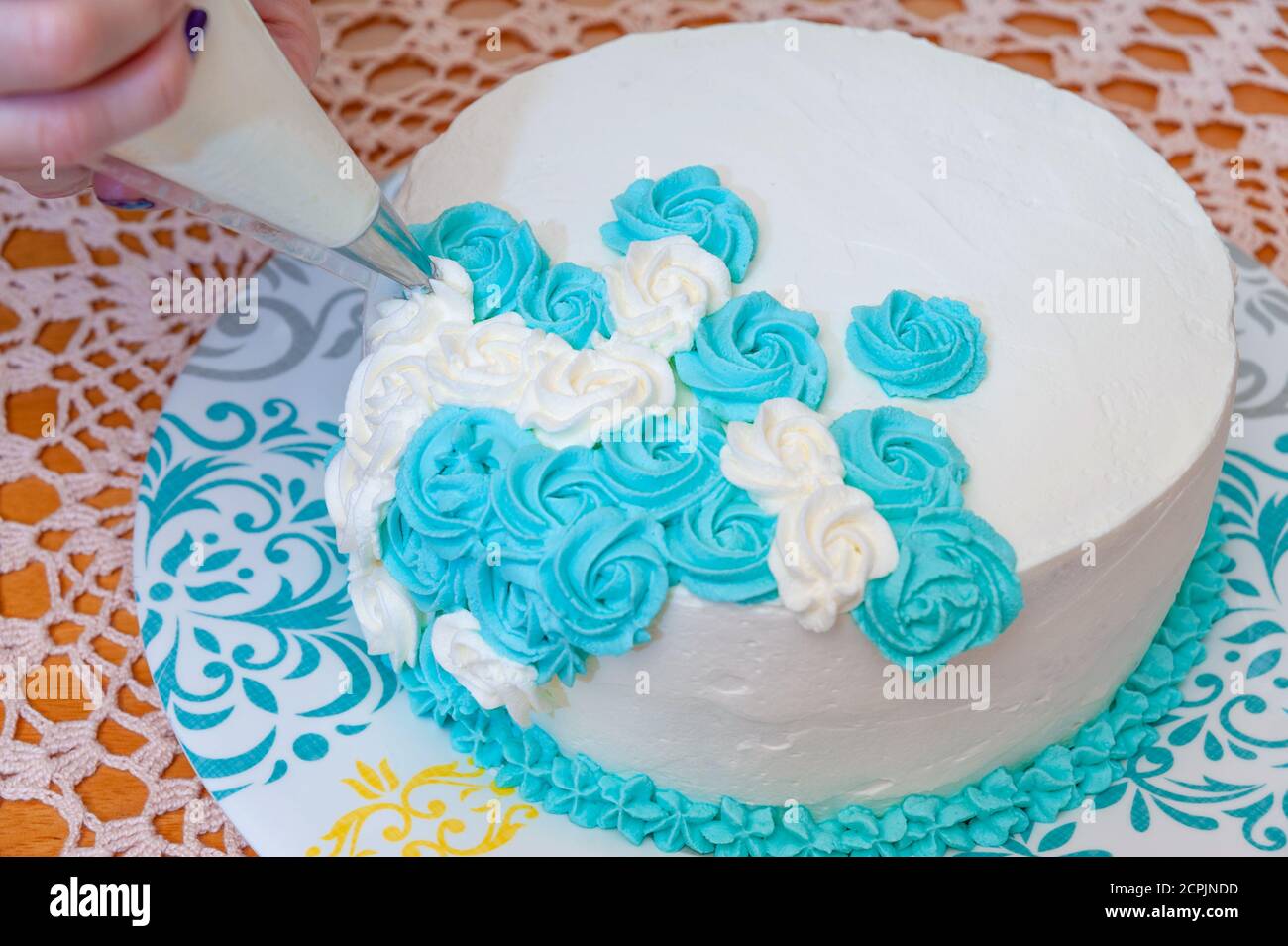 Hand decorating birthday cake with icing. Making homemade cake. Top ...