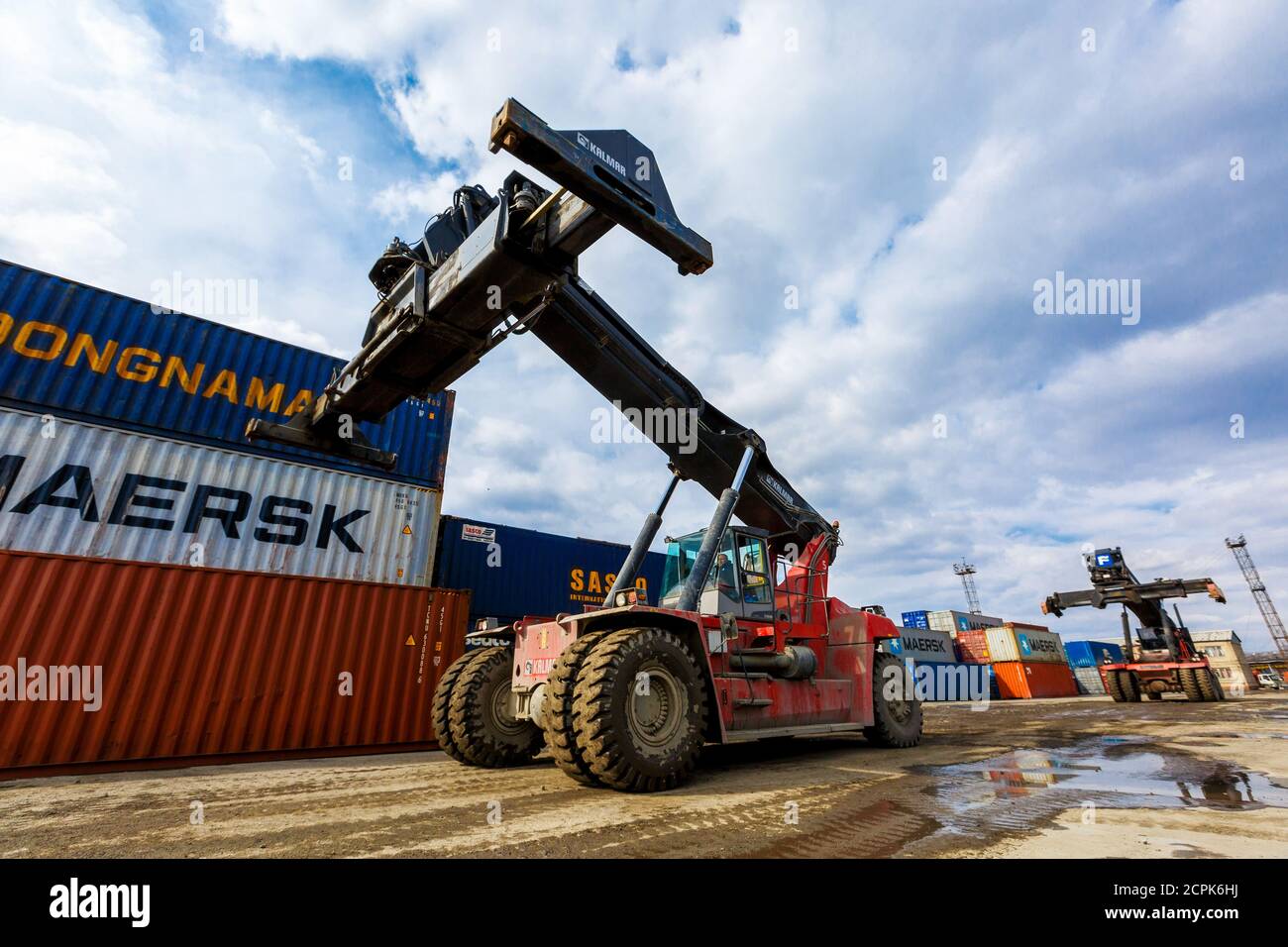 Container terminal. Large forklift lifts a metal container Stock Photo ...