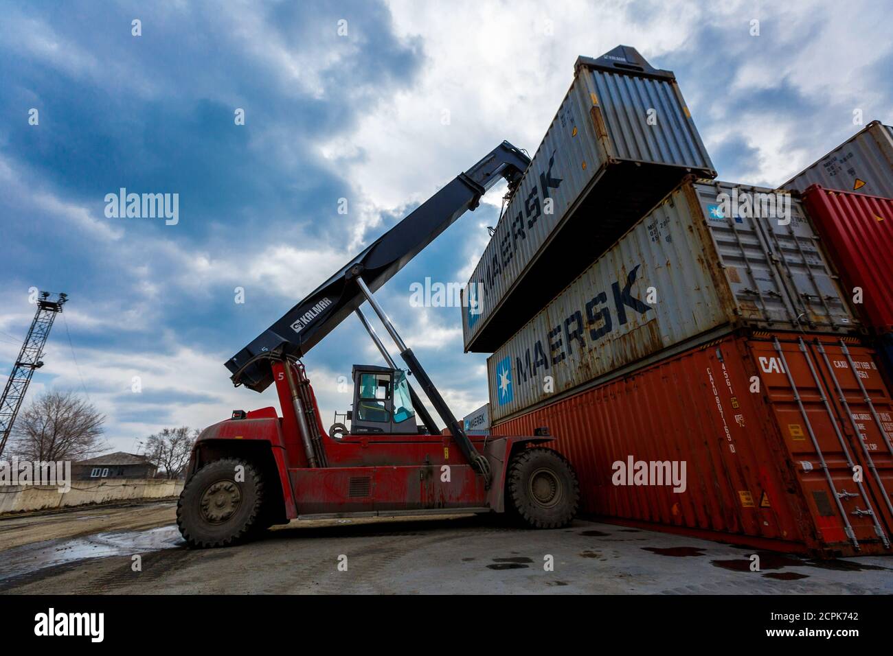 Container terminal. Large forklift lifts a metal container Stock Photo ...