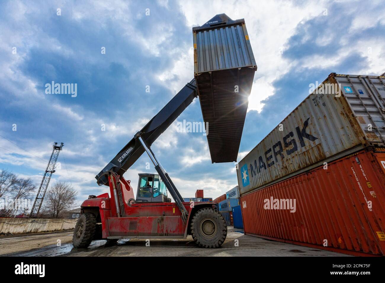 Container terminal. Large forklift lifts a metal container Stock Photo ...