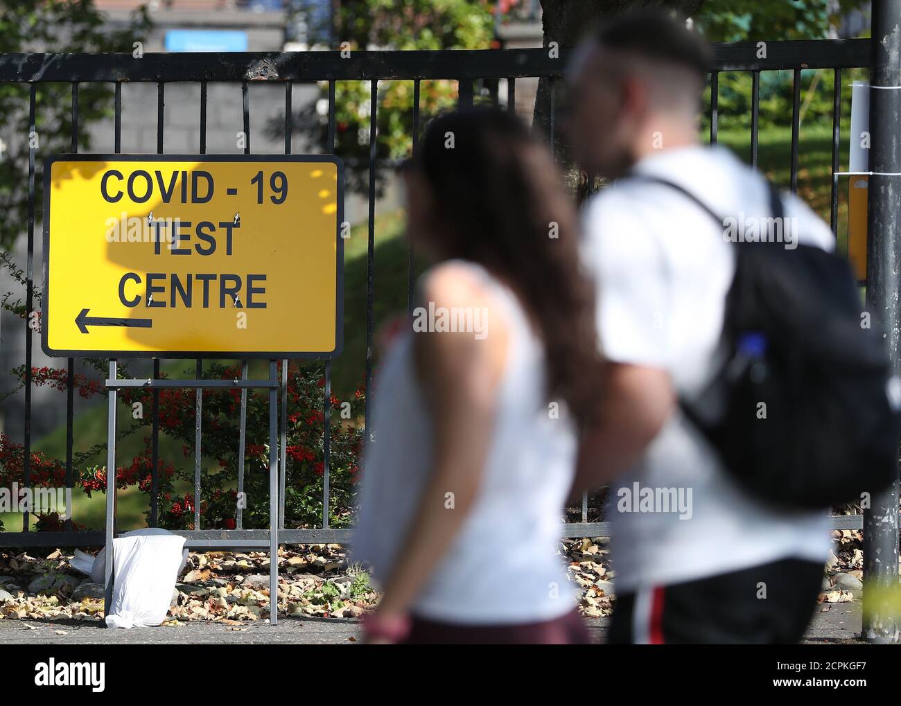 People pass a COVID-19 test centre sign at the new walk-through testing ...