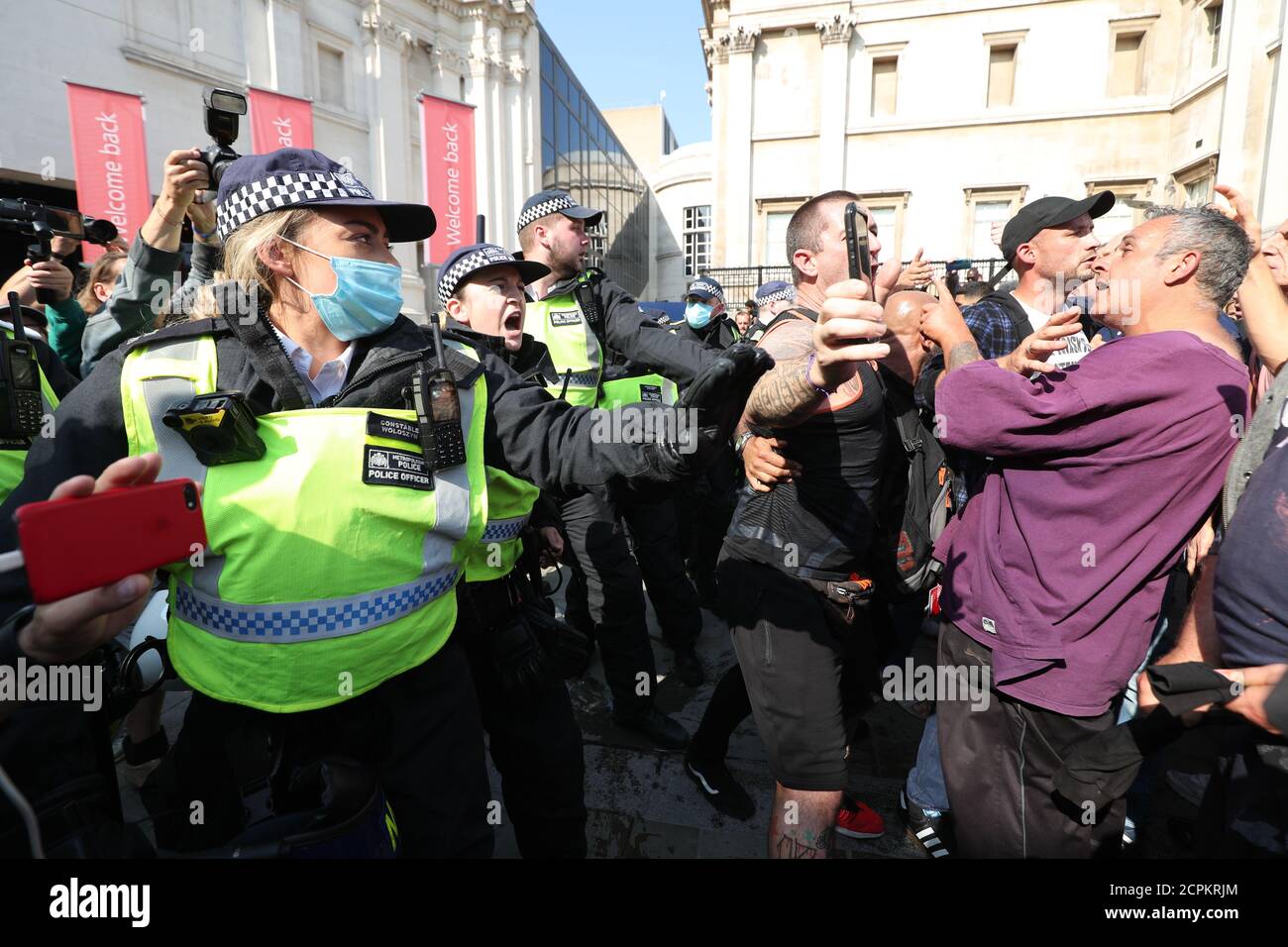 Police talk to demonstrators during an anti-vax protest in London's ...