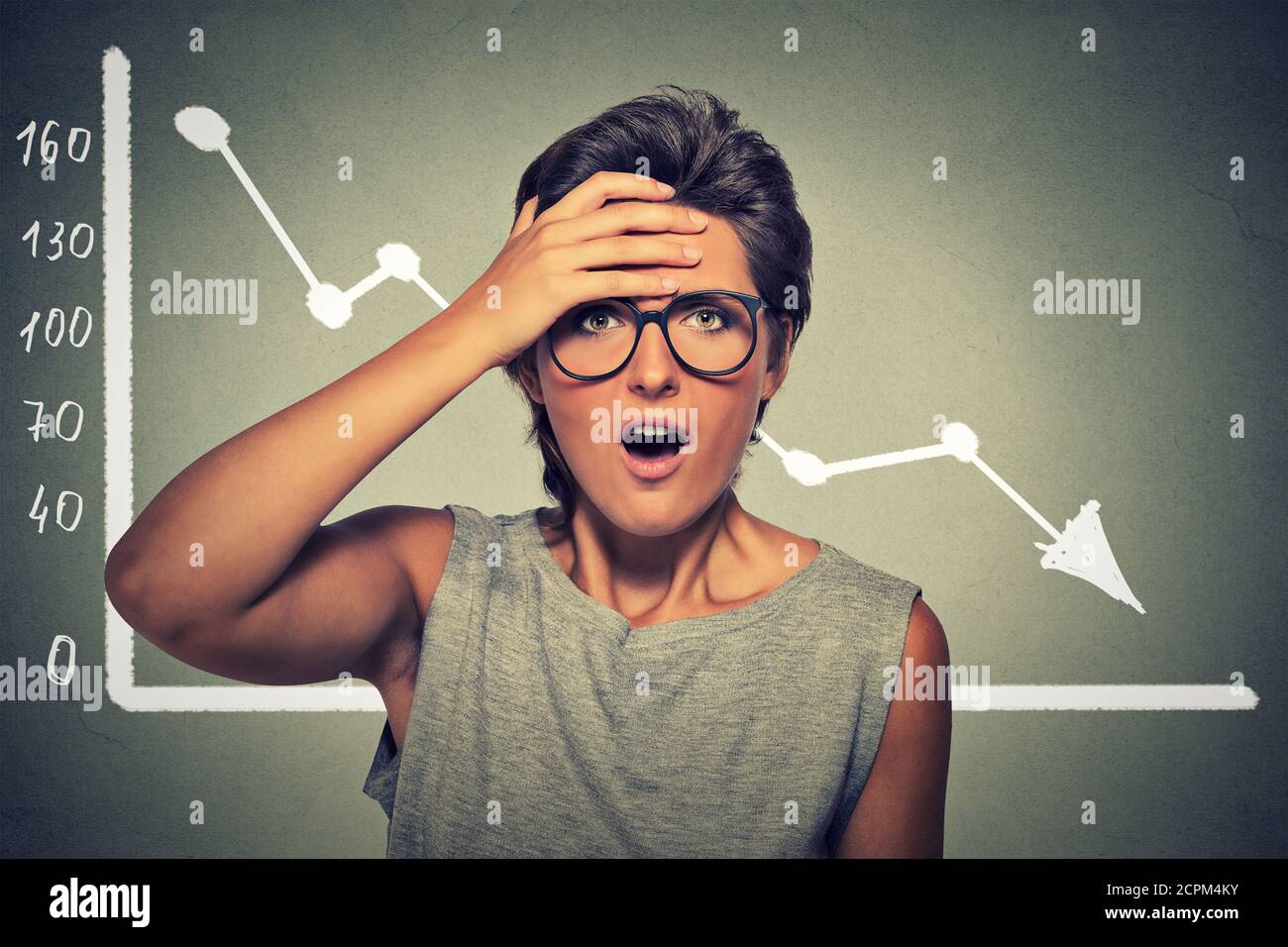 Shocked emotional young woman desperate with financial market chart ...