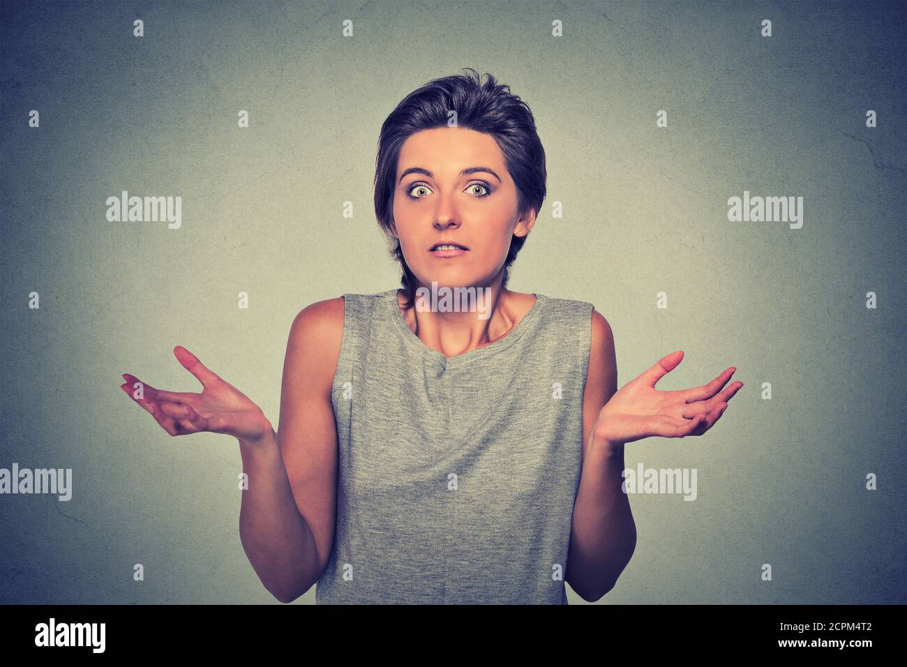 Portrait dumb looking woman arms out shrugs shoulders who cares so what ...