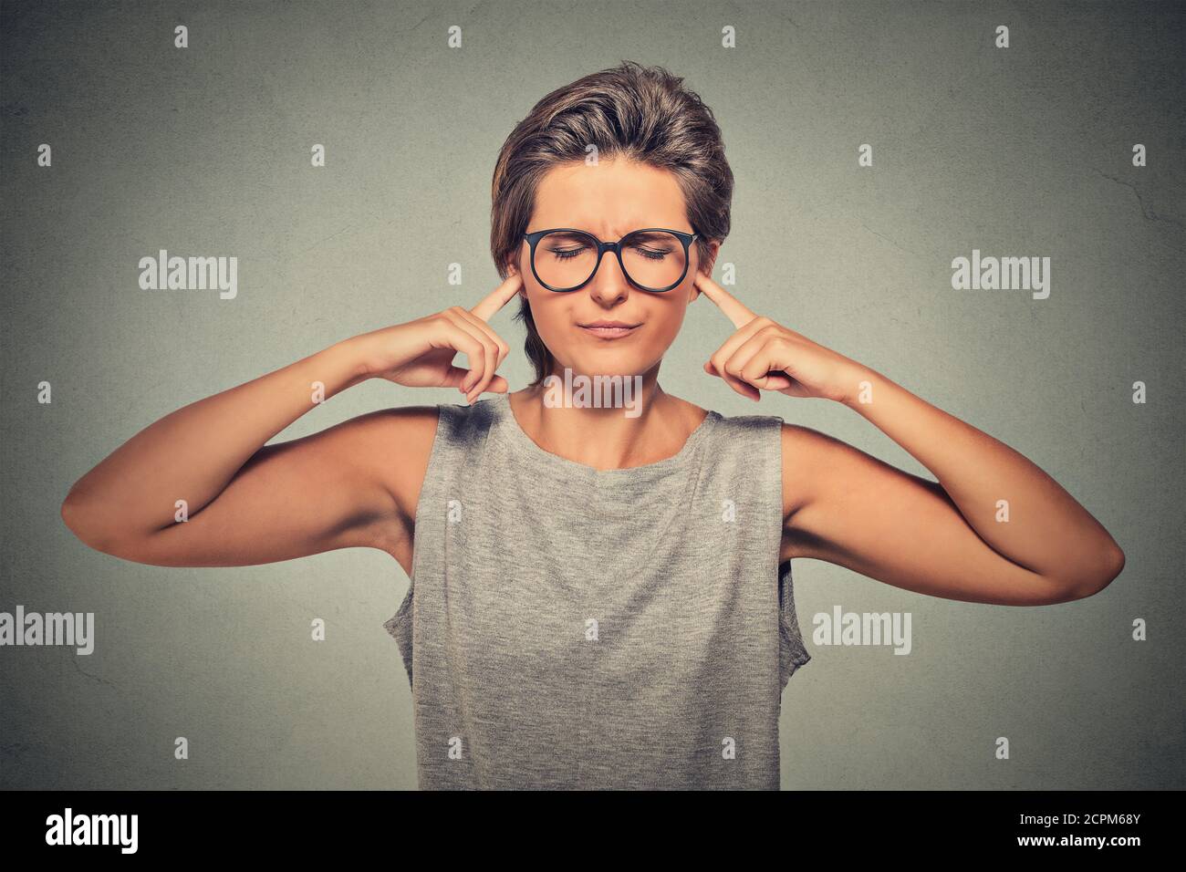 Woman plug ears eyes closed hi-res stock photography and images - Alamy