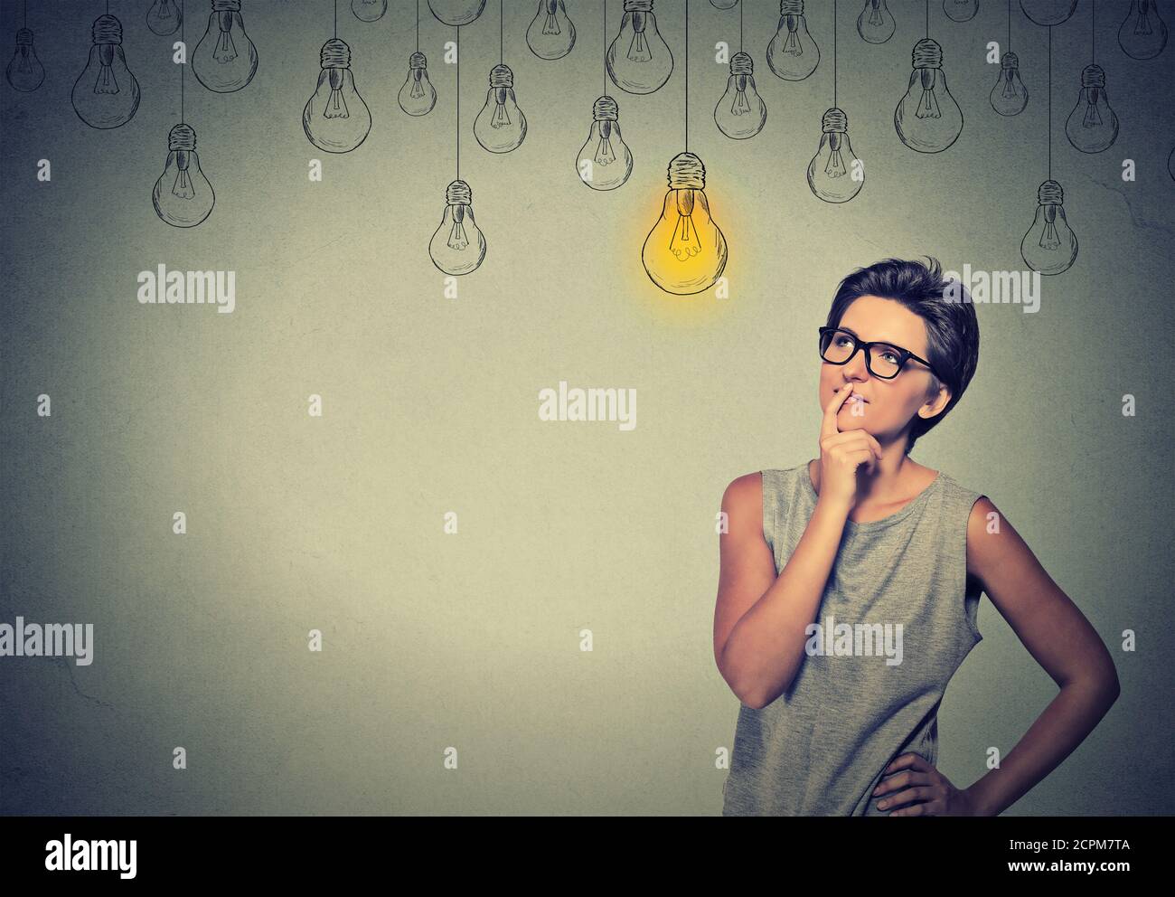 Big idea. Happy smart girl with glasses and solution lightbulb above ...