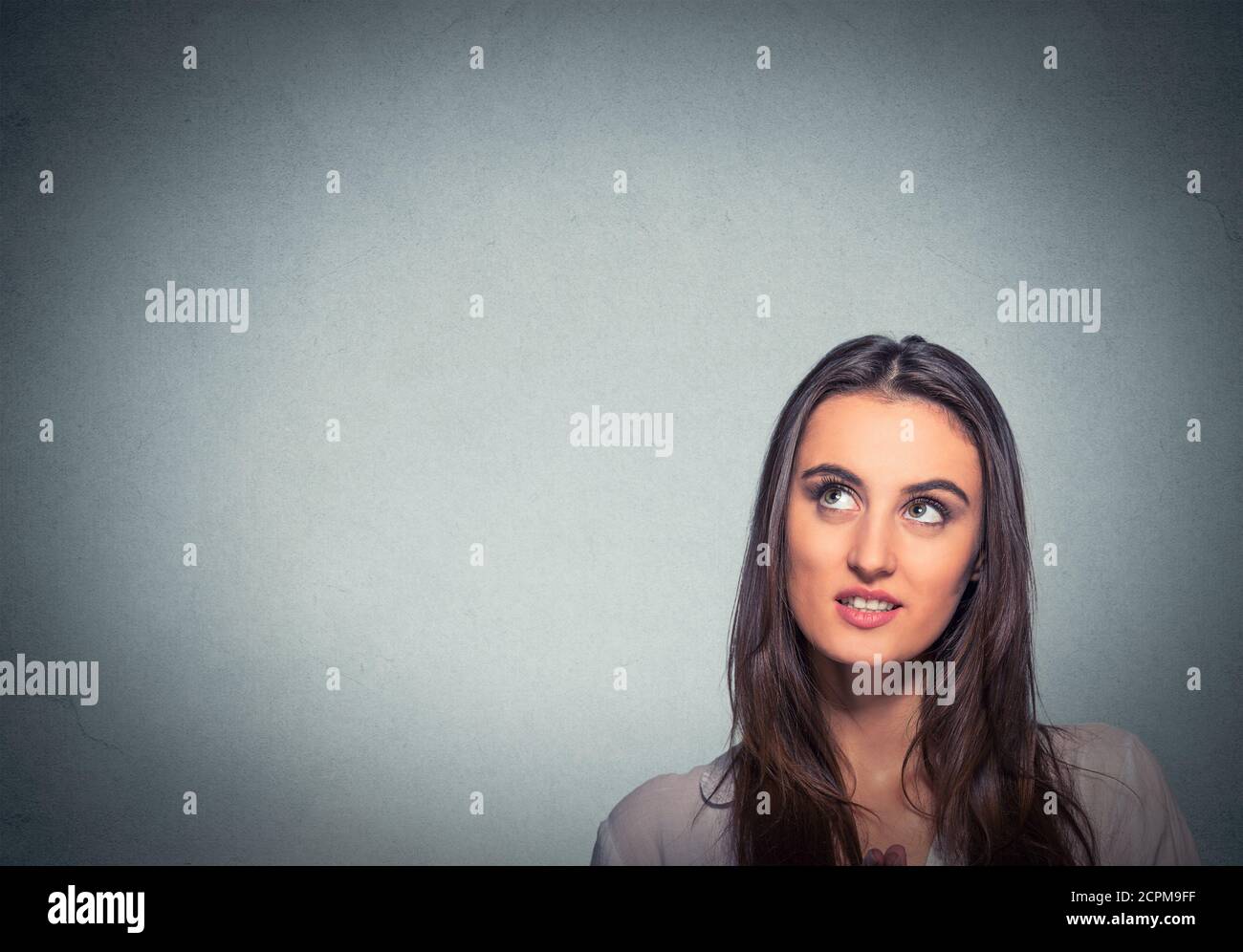 Portrait happy beautiful woman thinking looking up isolated on gray ...