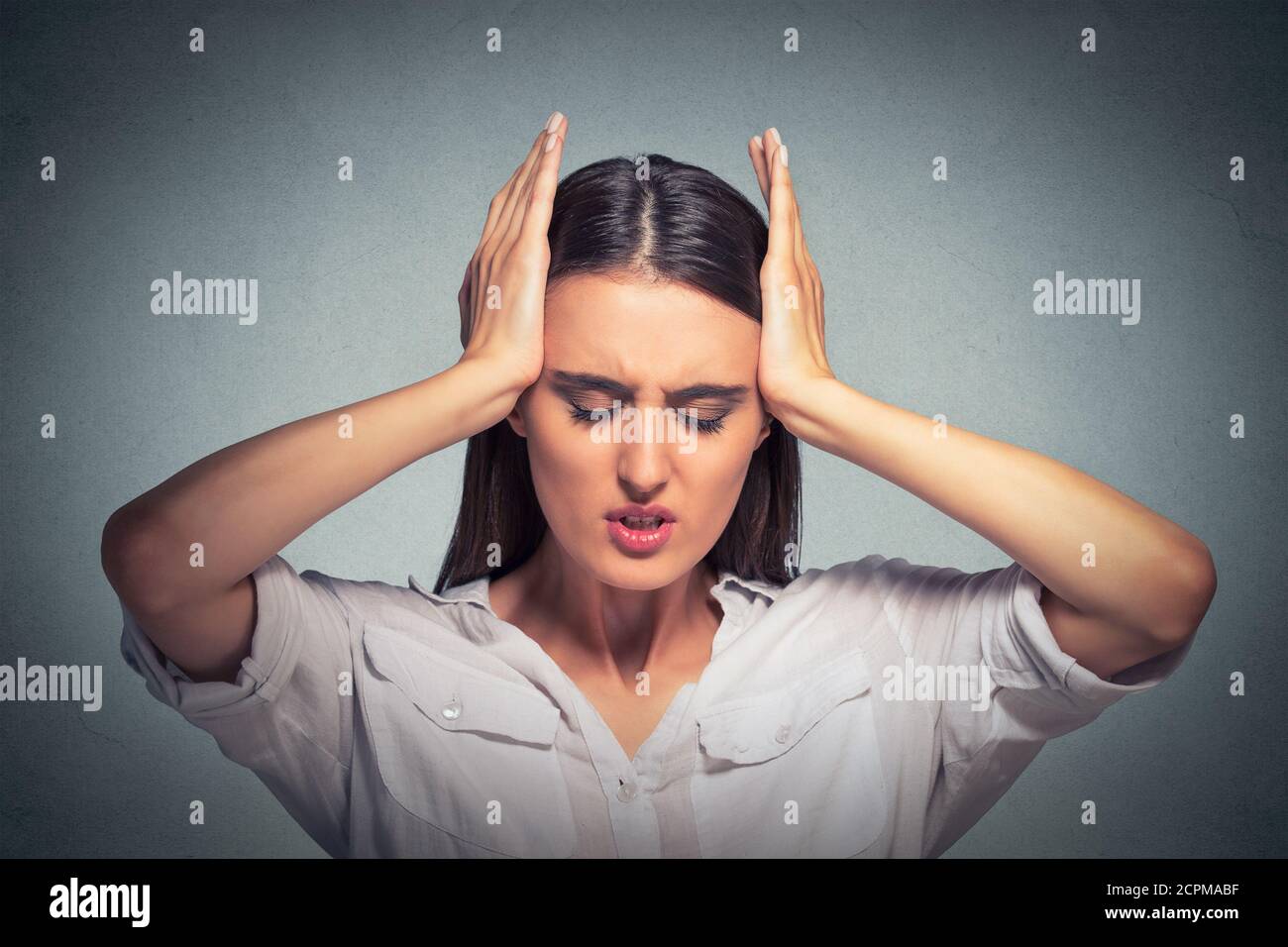 Stressed sad woman, having migraine, tension headache isolated on gray ...