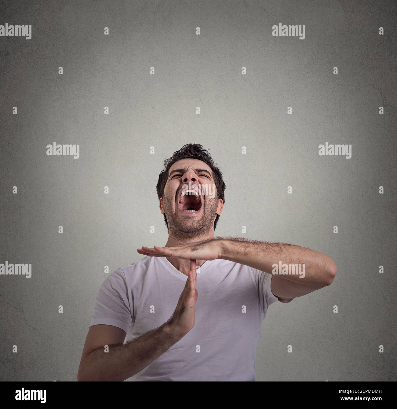 Young man showing time out hand gesture, frustrated screaming to stop ...