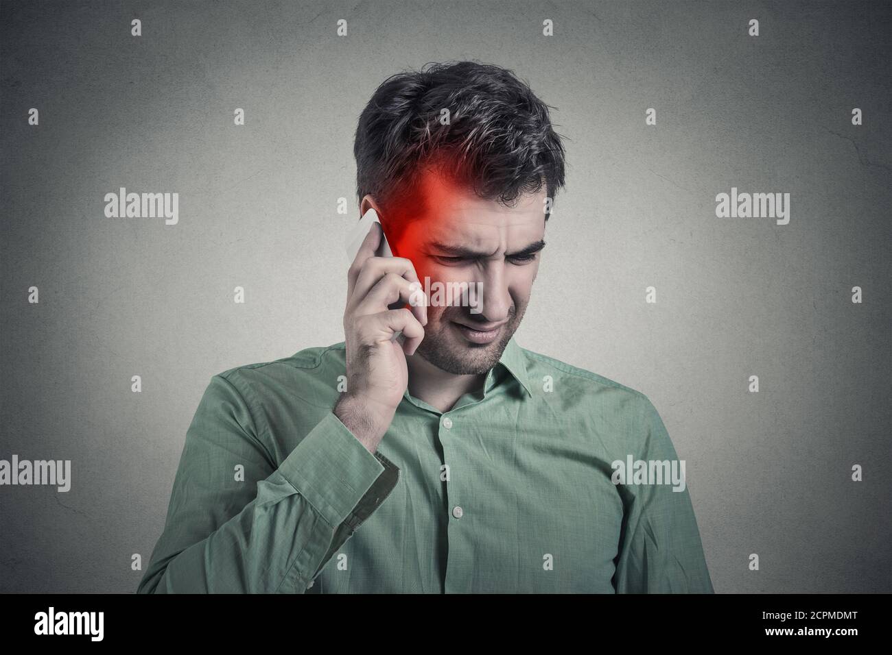 Man on the phone with headache. Upset unhappy guy talking on a phone ...