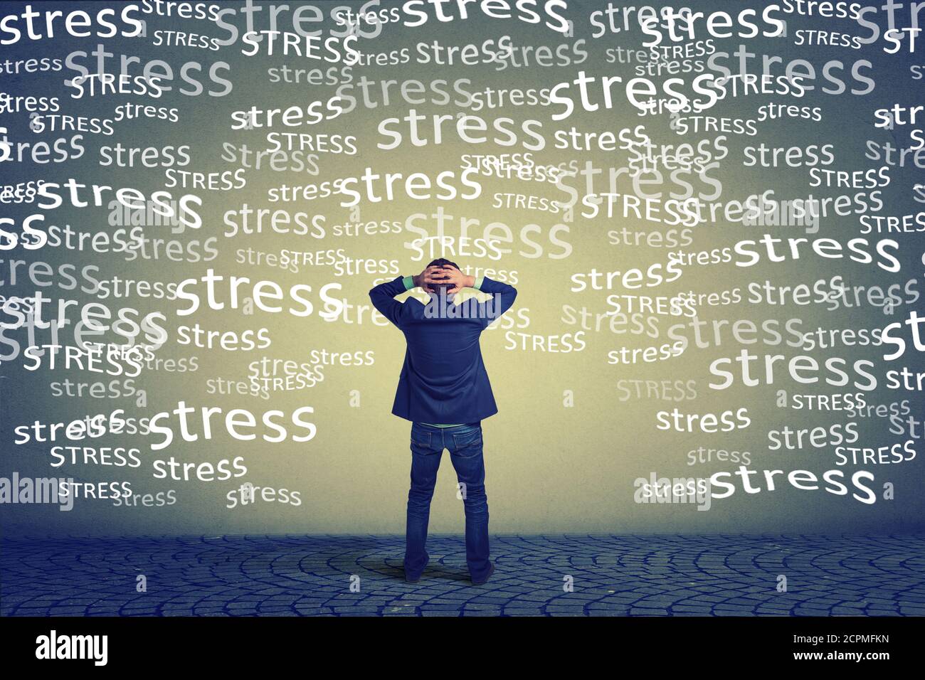 Rear view of stressed business man standing in front of a wall hands on ...