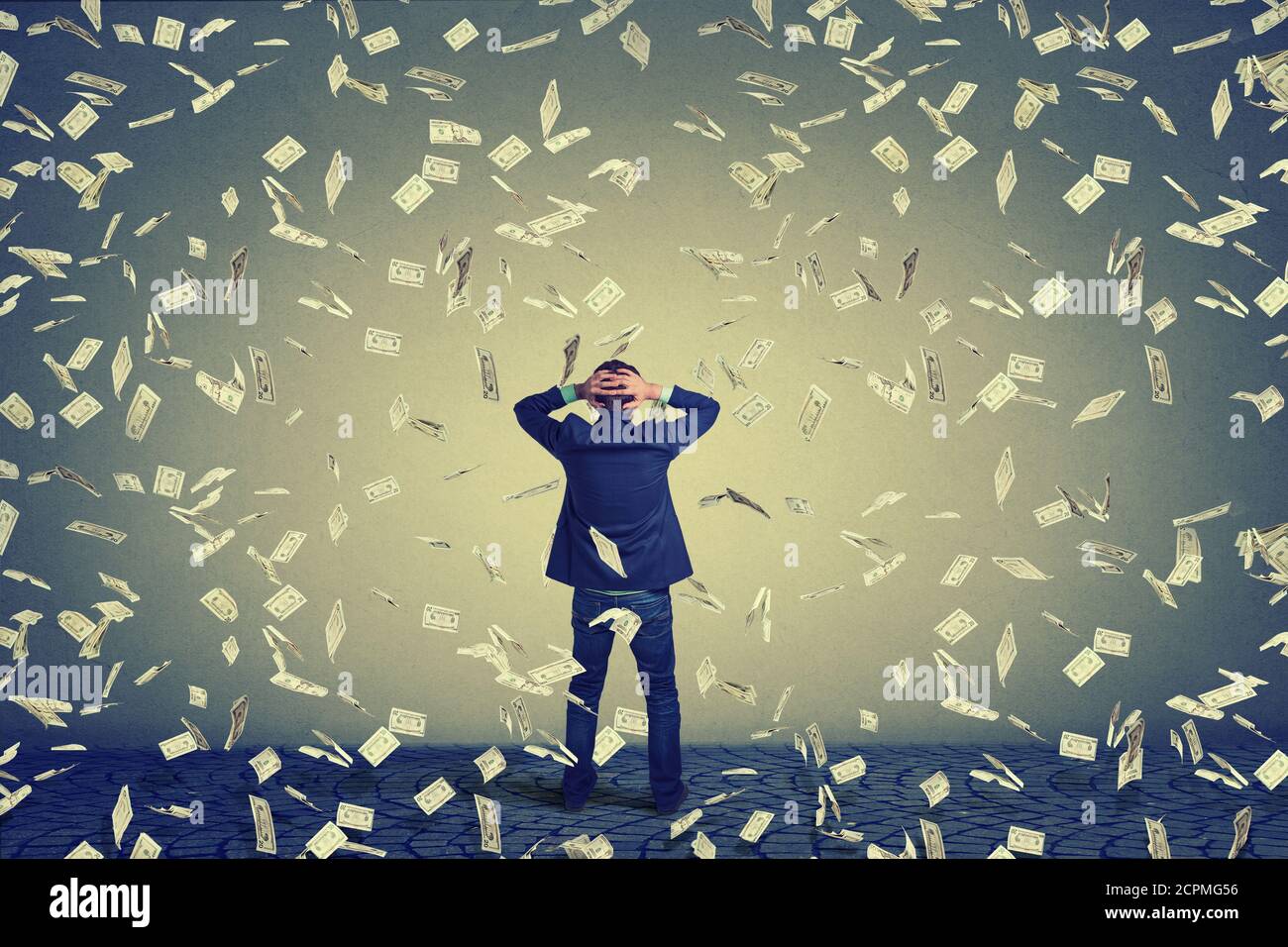 Rear back view of business man standing in front of a wall under money ...