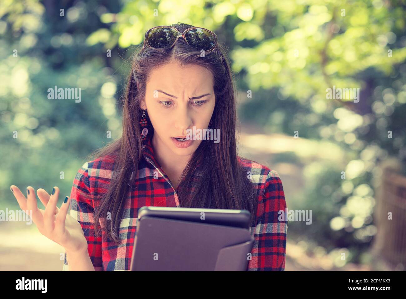 Portrait upset sad skeptical unhappy serious woman using mobile pad ... Portrait upset sad skeptical unhappy serious woman using mobile pad ...