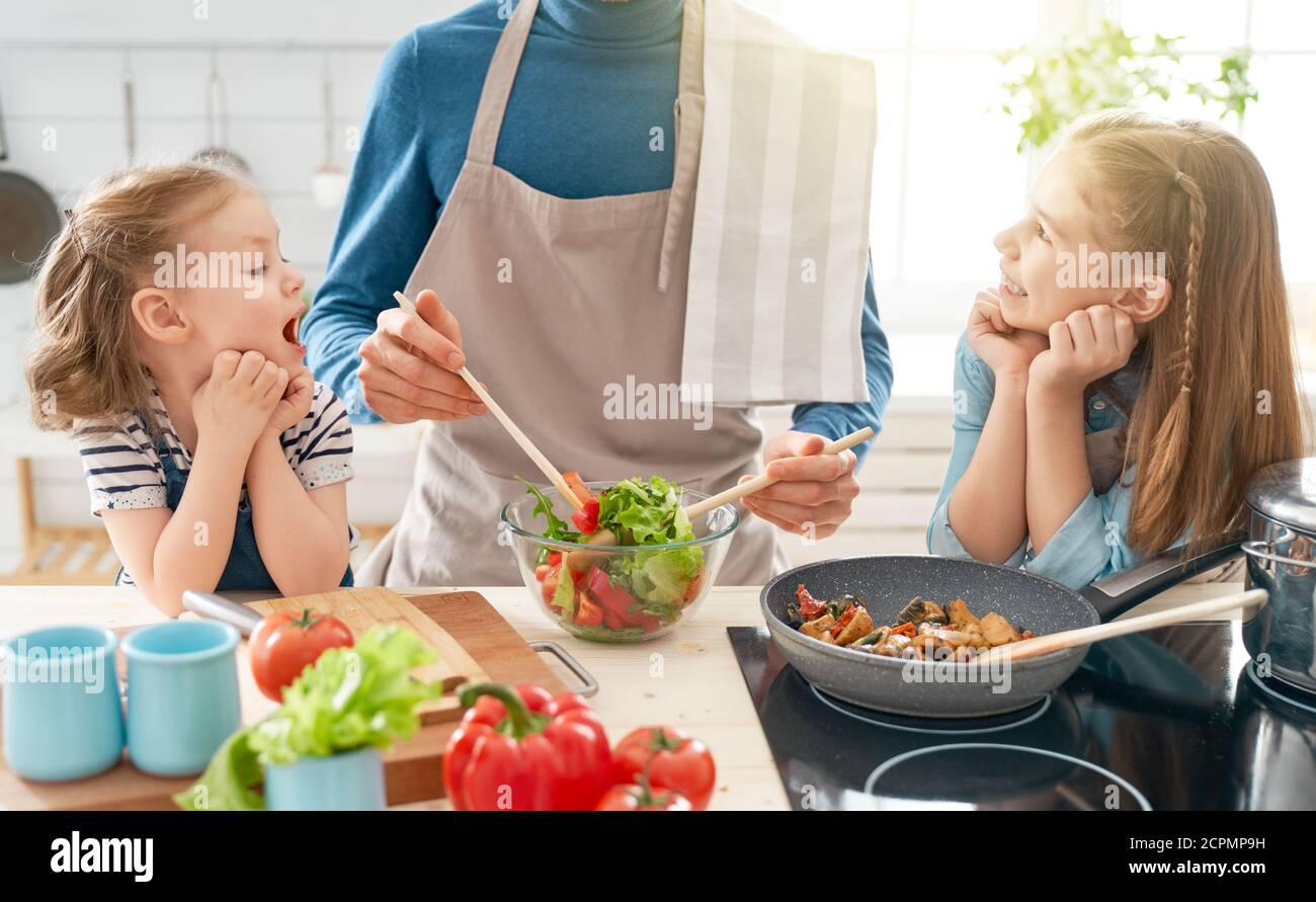 Healthy food at home. Happy family in the kitchen. Father and children ...