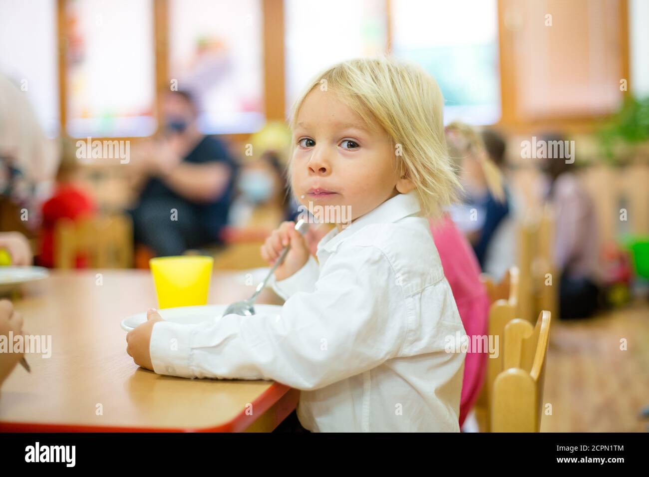 Blond toddler child, eating breakfast in kindergarden Stock Photo - Alamy