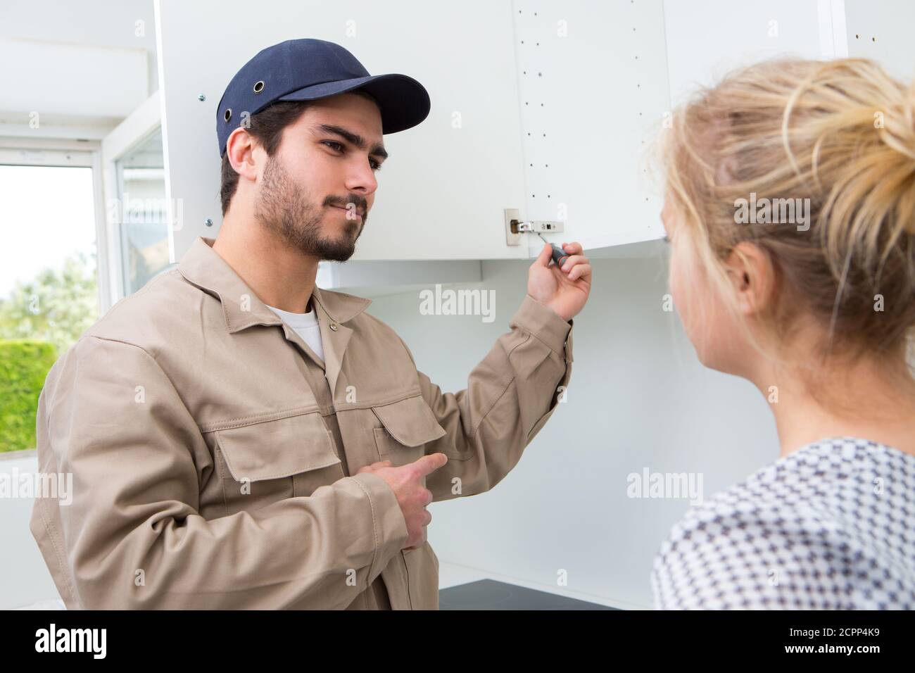 engineer giving woman advice on kitchen repair Stock Photo - Alamy