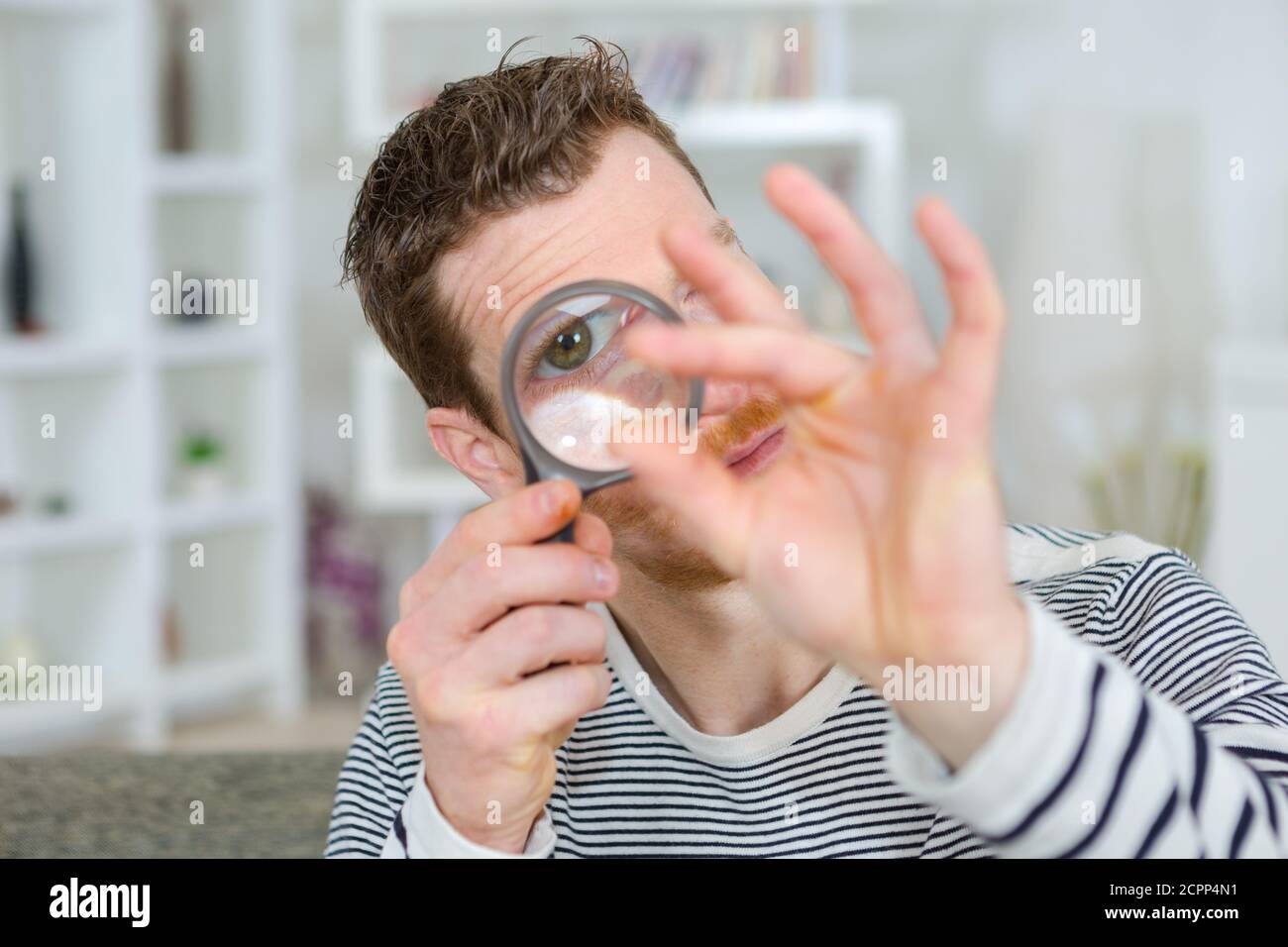 man looking at ring through magnifying glass Stock Photo - Alamy
