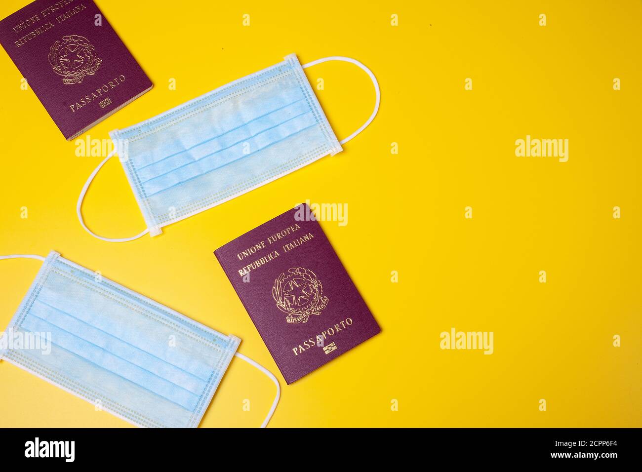 blue medical facial mask on a yellow background and italian passports ...