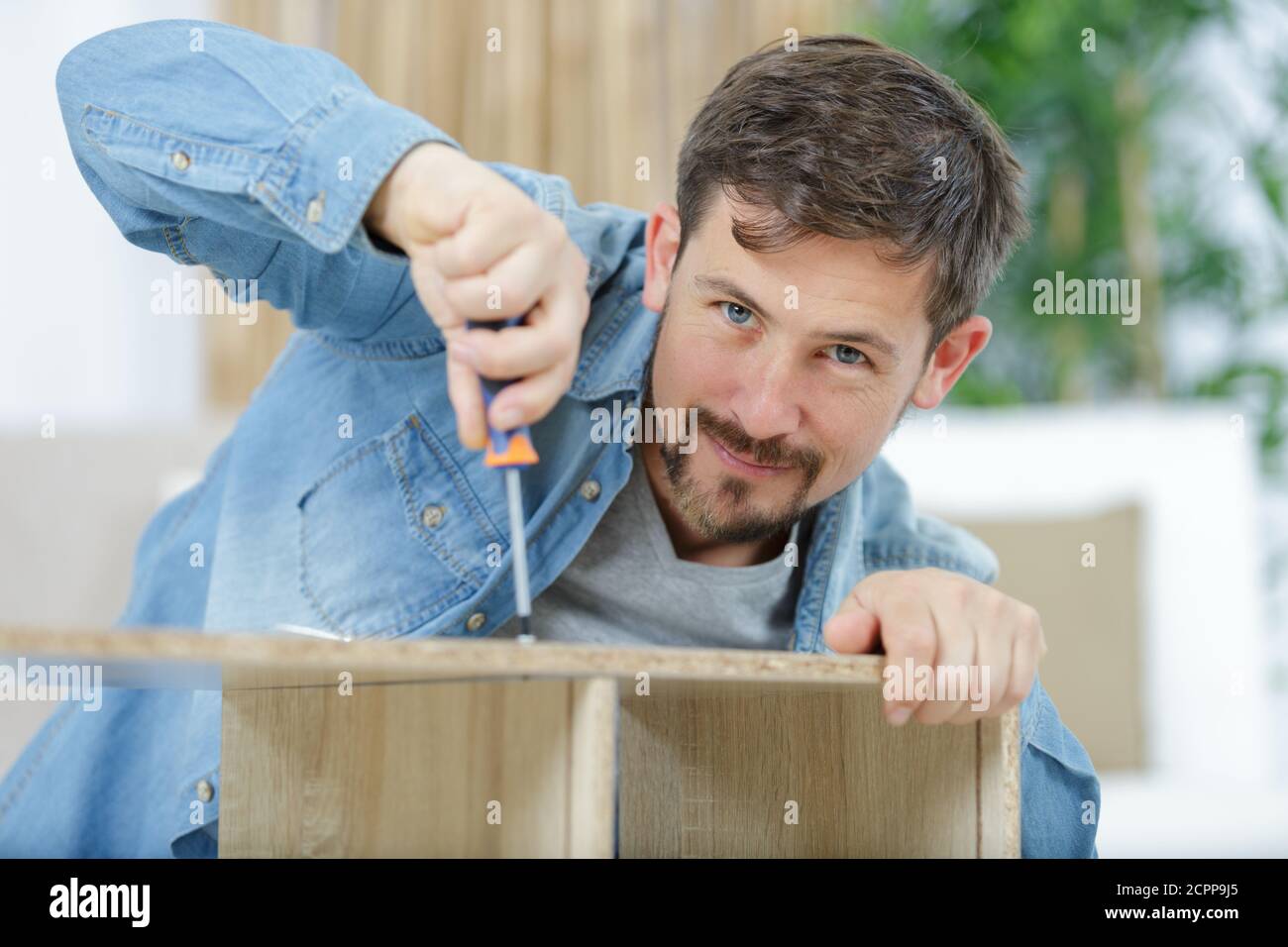 content man assembling furniture at home Stock Photo - Alamy