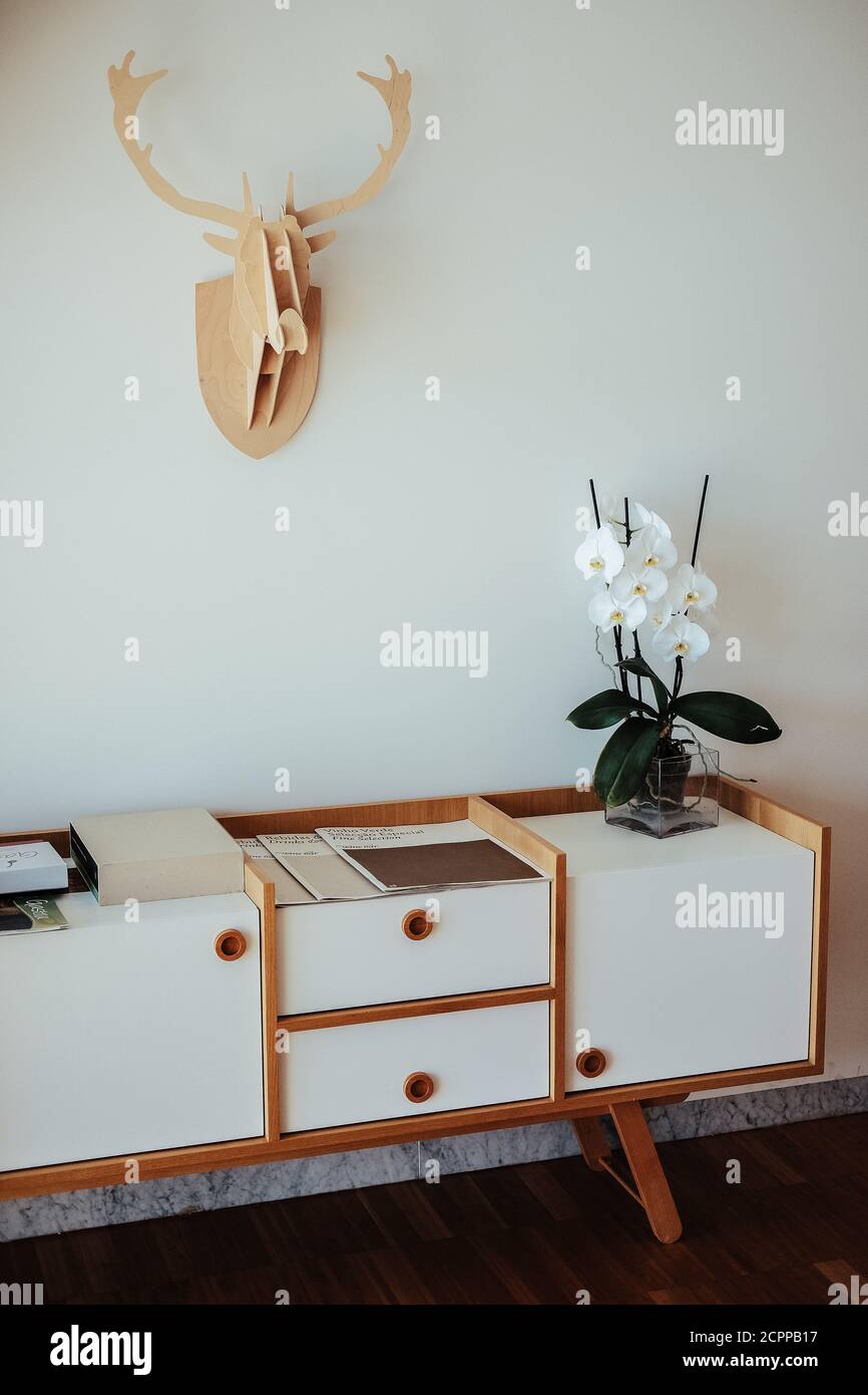 Stylish interior design of the living room with wooden commode and ...