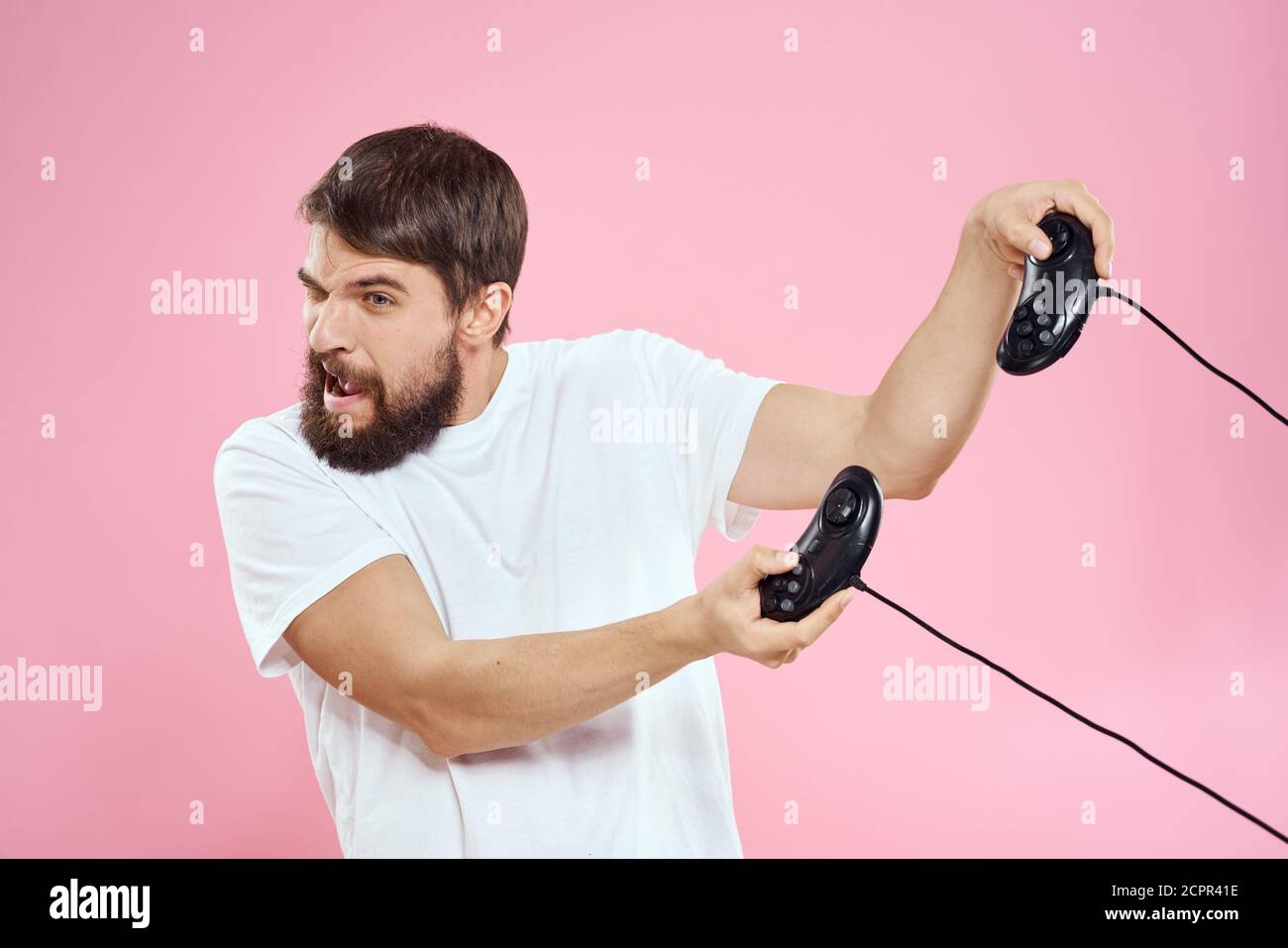 Man with two joysticks in hands fun game technology lifestyle pink ...