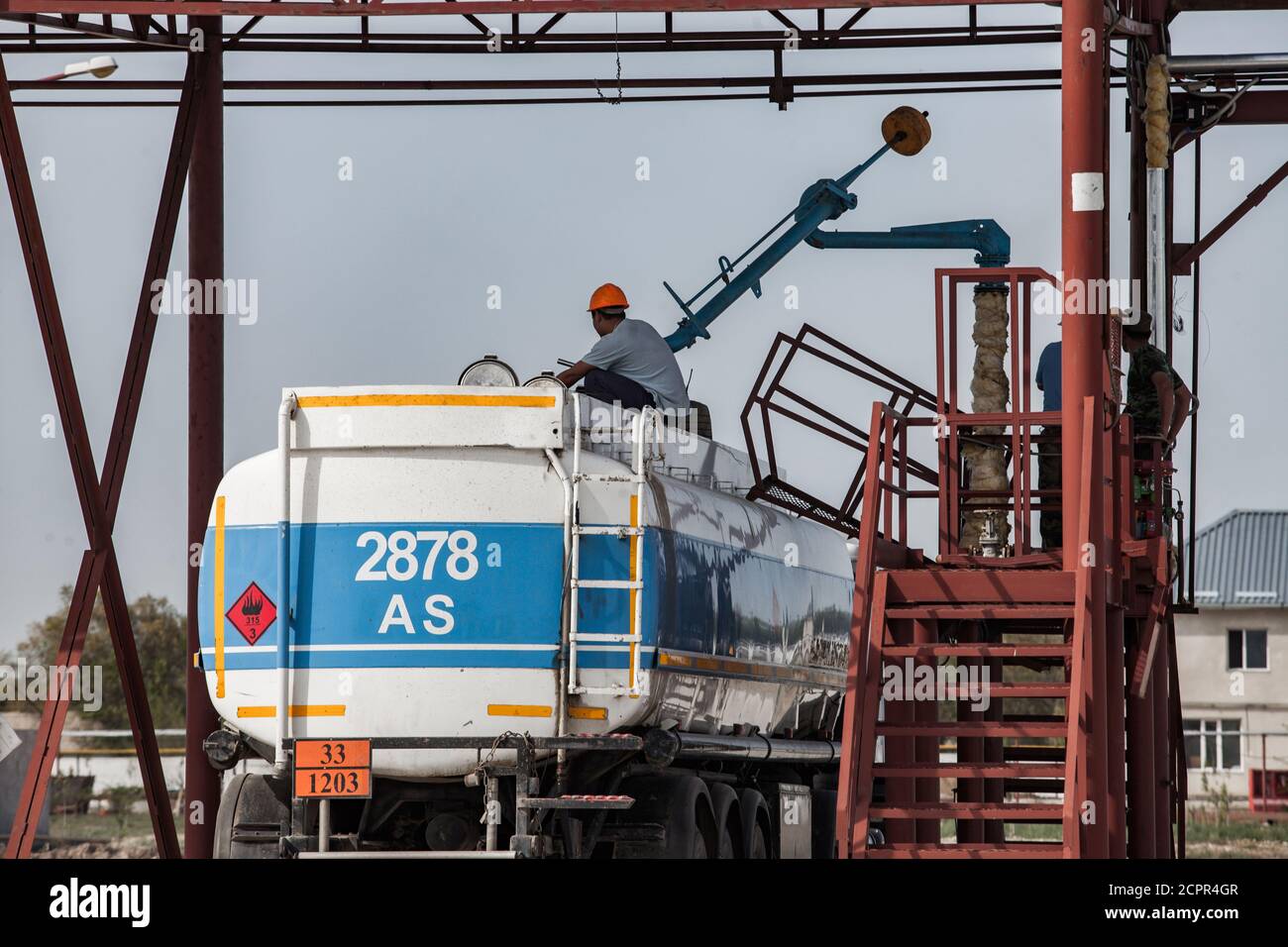 Tank truck filling station or terminal on oil refinery plant. Worker on ...
