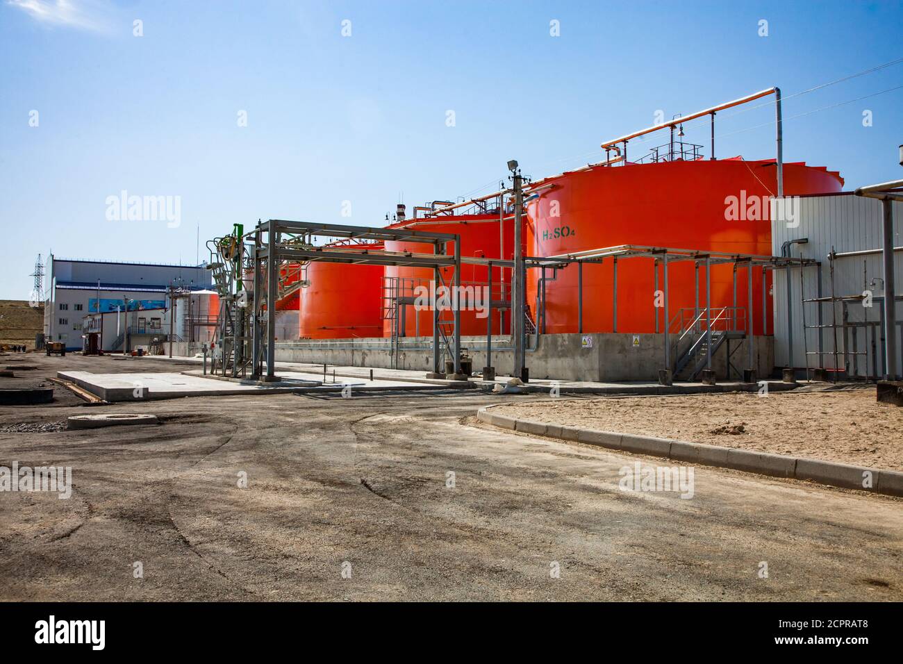 Orange metal storage tanks with acid and its formula on sulfuric ...