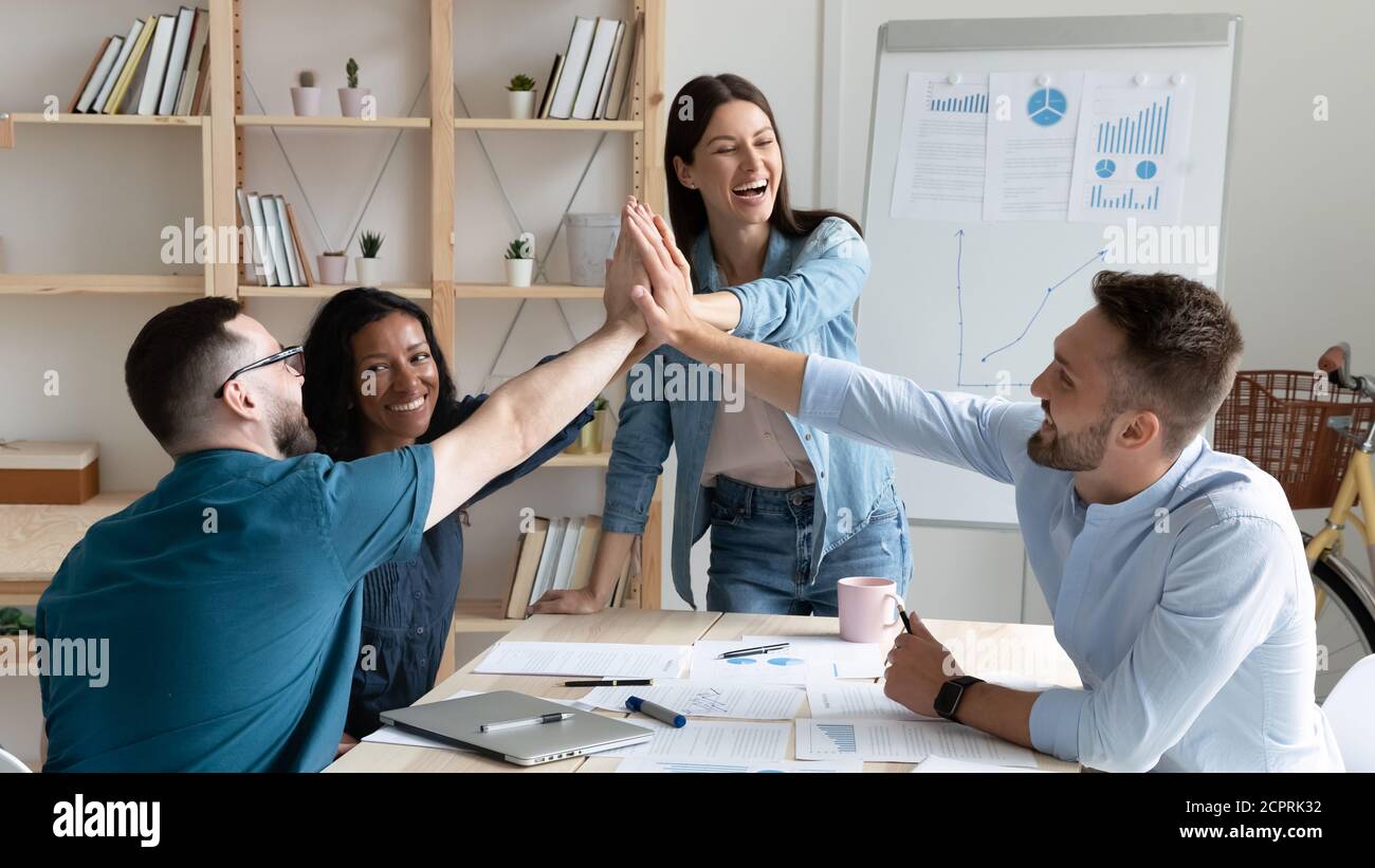 Overjoyed employees team giving high five, celebrating success Stock ...