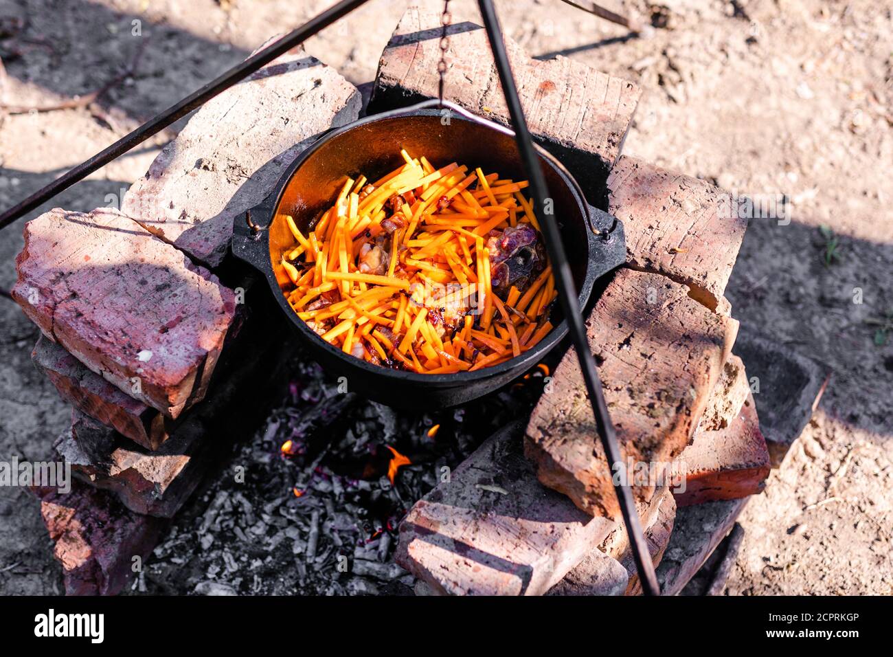 Preparation of pilaf in a cauldron on an open fire Stock Photo - Alamy