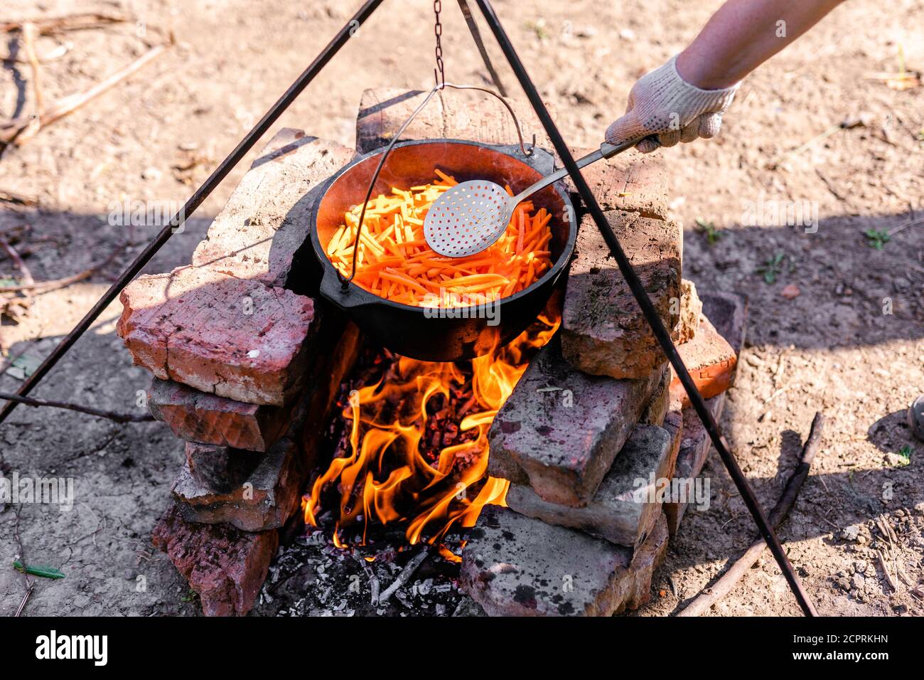 Preparation of pilaf in a cauldron on an open fire Stock Photo - Alamy