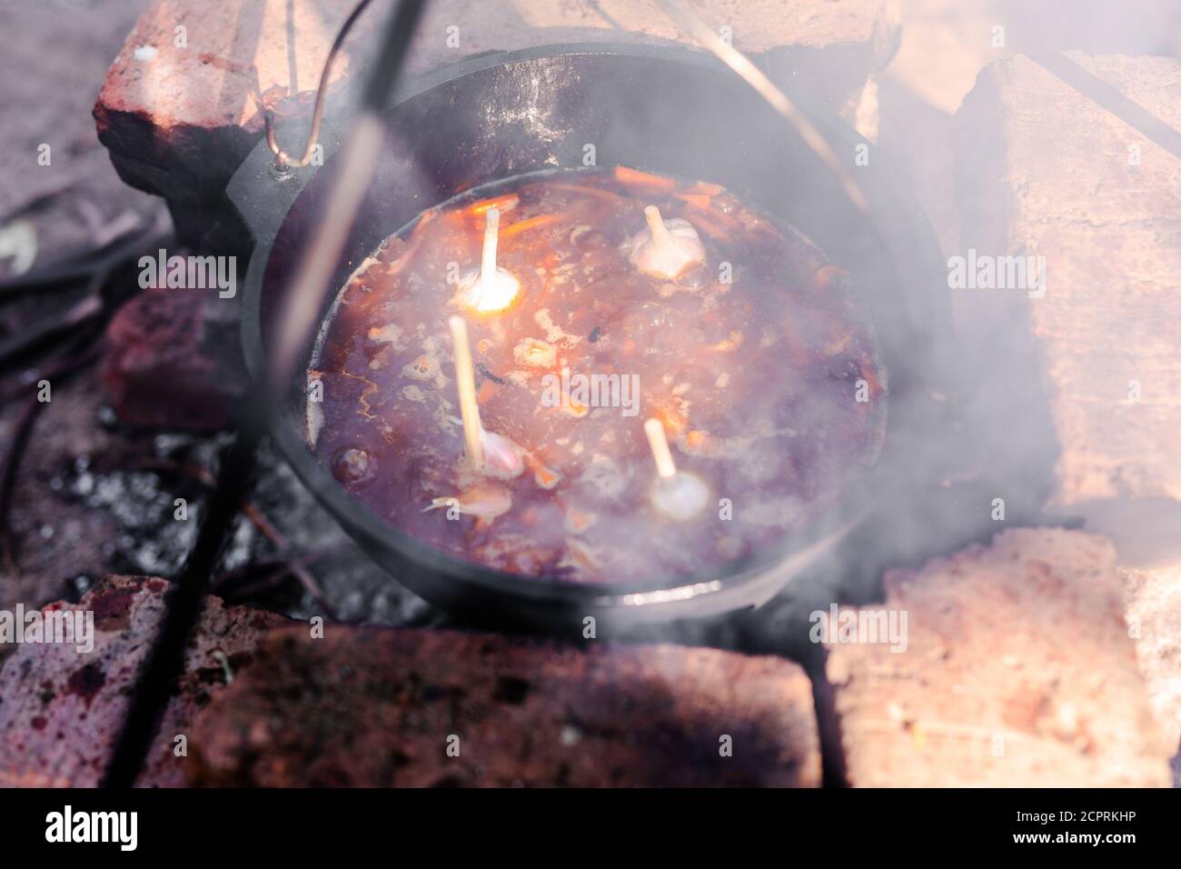 Preparation of pilaf in a cauldron on an open fire Stock Photo - Alamy