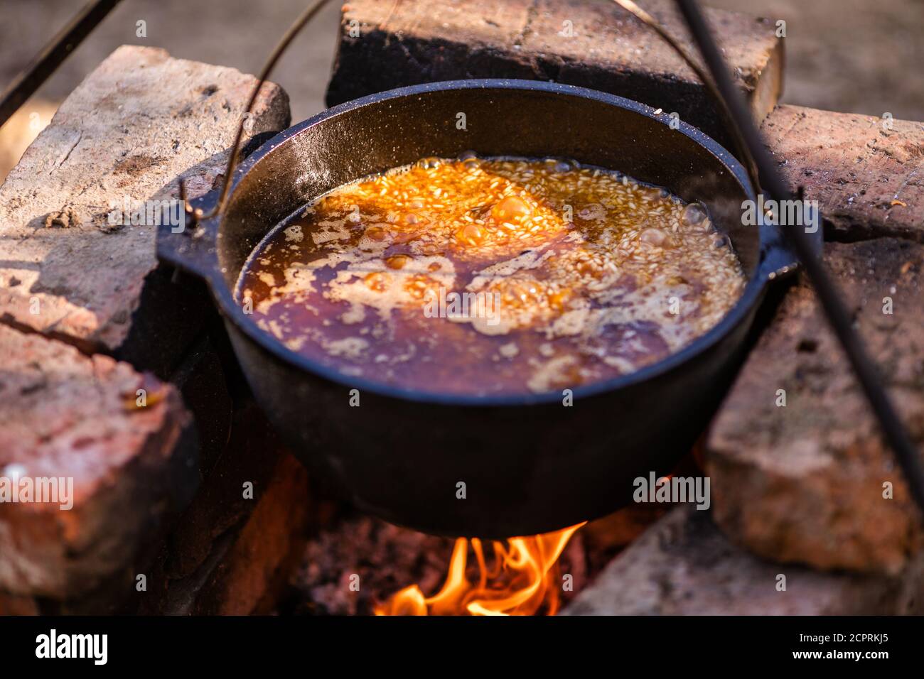 Preparation of pilaf in a cauldron on an open fire Stock Photo - Alamy