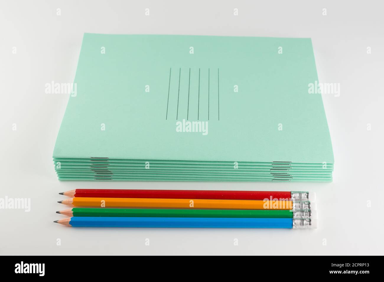 stack of thin student notebooks with colored pencils for school Stock ...