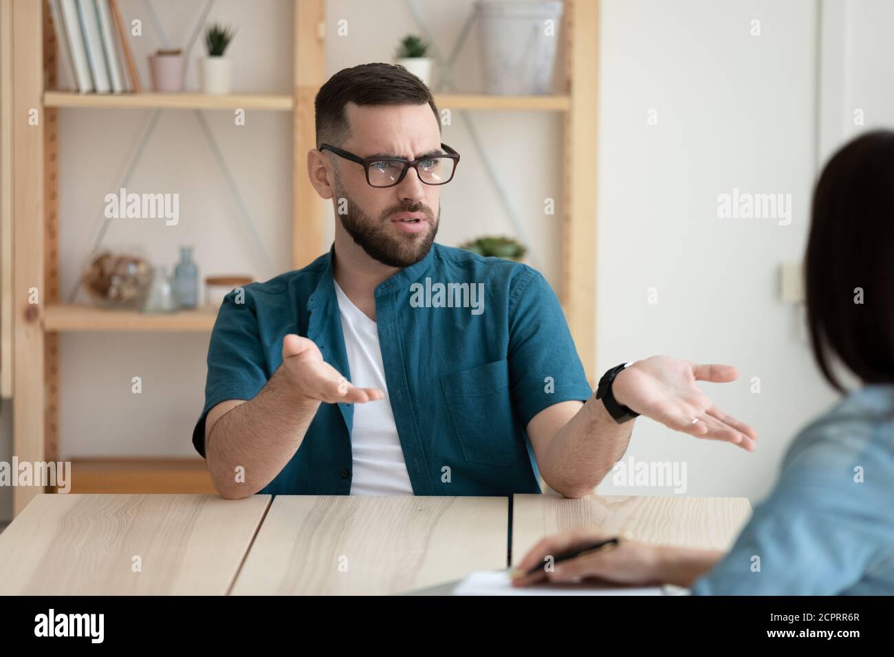 Dissatisfied client young man wearing glasses arguing with manager ...