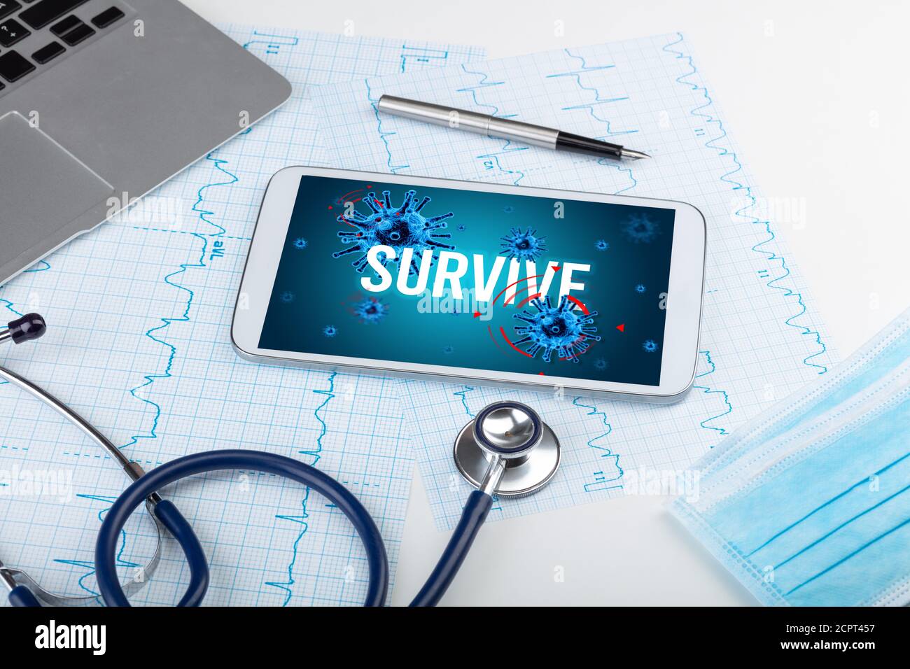 Tablet pc and doctor tools on white surface with SURVIVE inscription ...