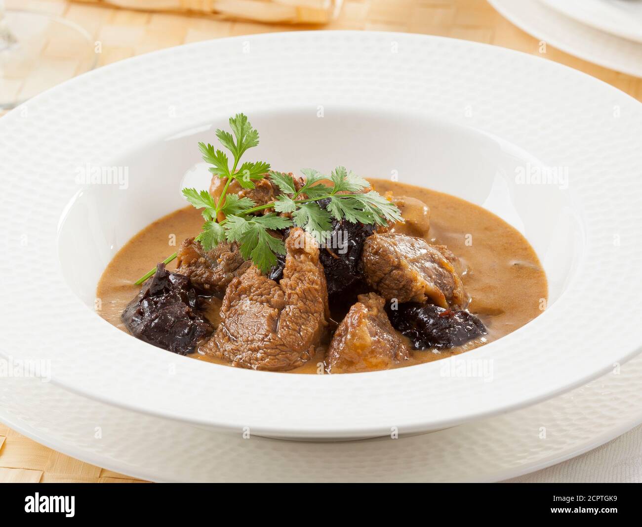 Beef stew served with plums Stock Photo - Alamy