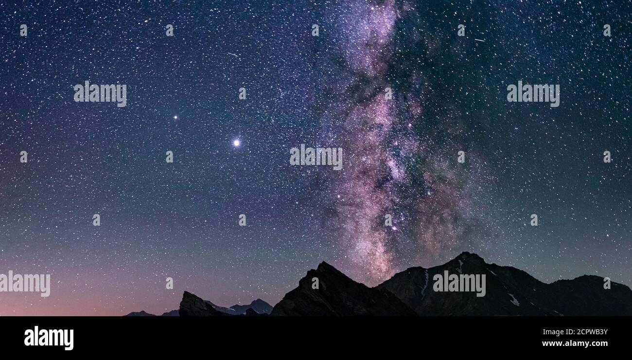 The Milky Way core and glowing stars in the night sky oover the Alps ...