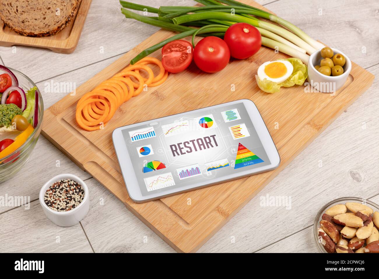 Organic food and tablet pc showing RESTART inscription, healthy ...