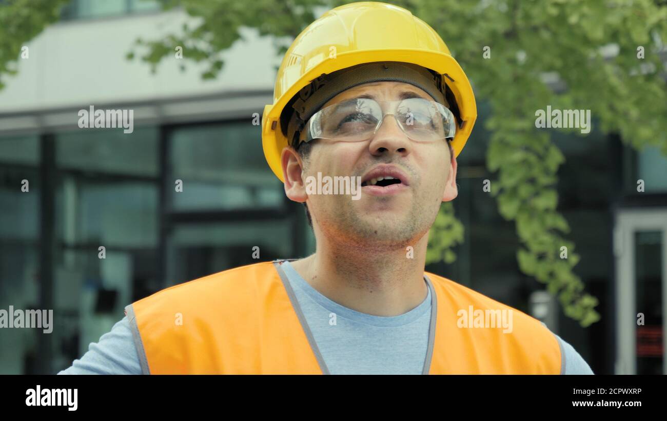 Surprised worker looking at the building Stock Photo - Alamy