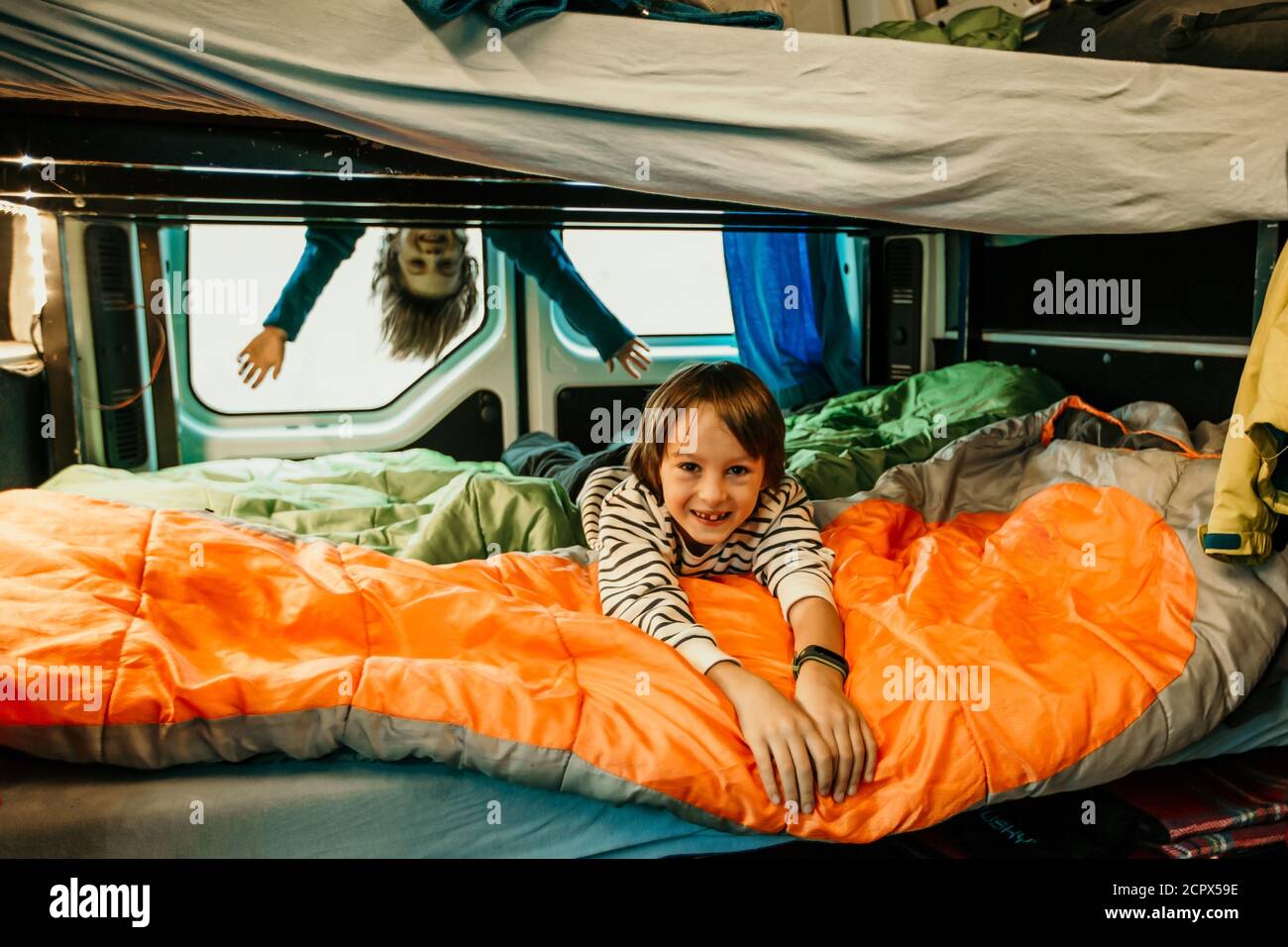 Children, having fun in camper van while heavy raining outdoors ...