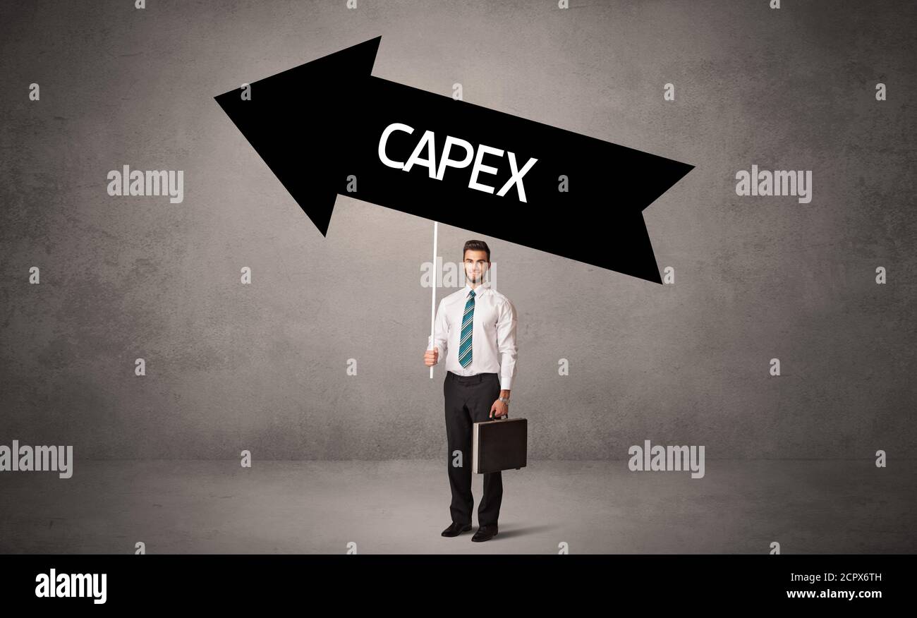 Young business person in casual holding road sign with CAPEX ...