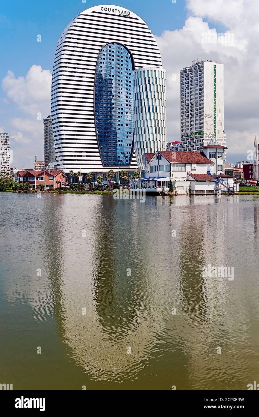 The modern building in Batumi and its reflection in the water in ...