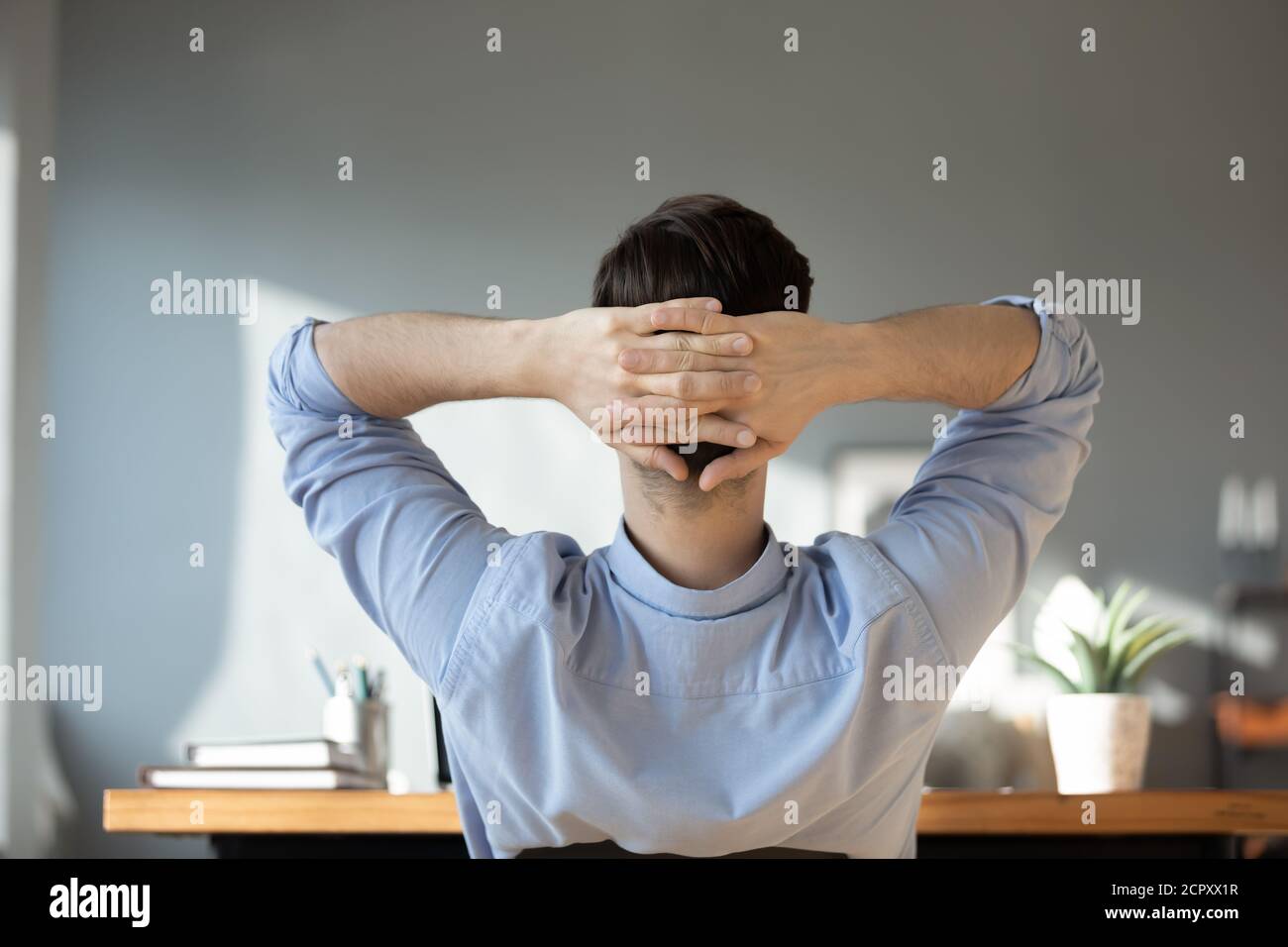 Back view of man relax at home office workplace Stock Photo - Alamy