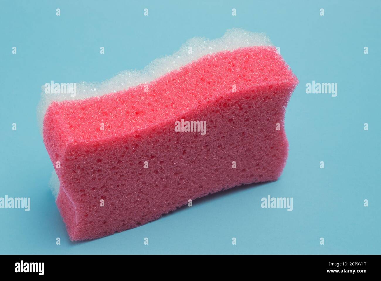 red porous bath sponge on side on blue paper background Stock Photo - Alamy