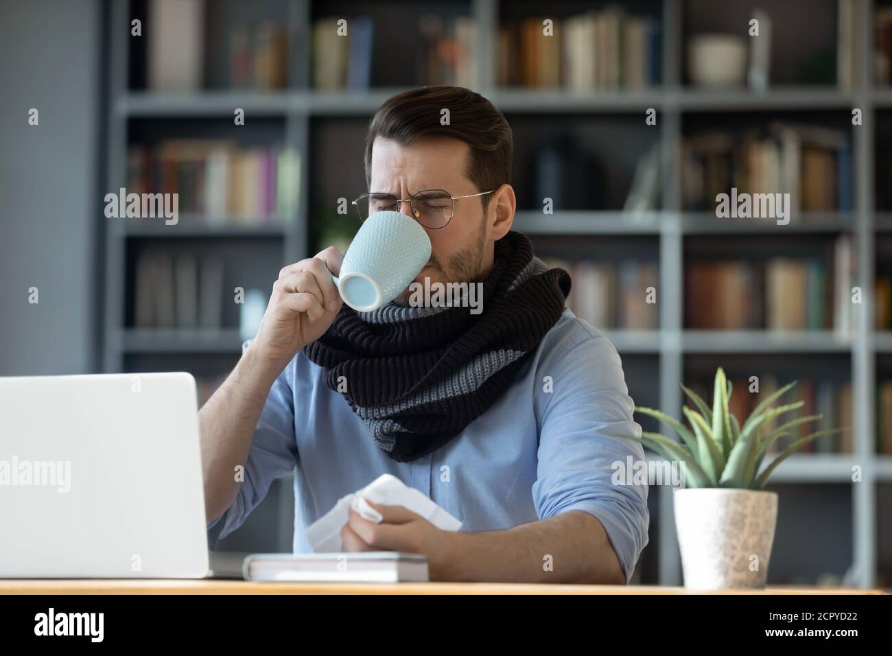 Unhealthy young man drink tea suffering from influenza Stock Photo - Alamy