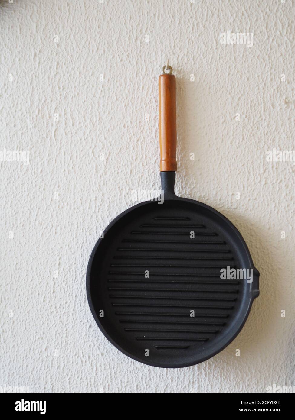 Vertical closeup of a pan hanging from a wall Stock Photo - Alamy