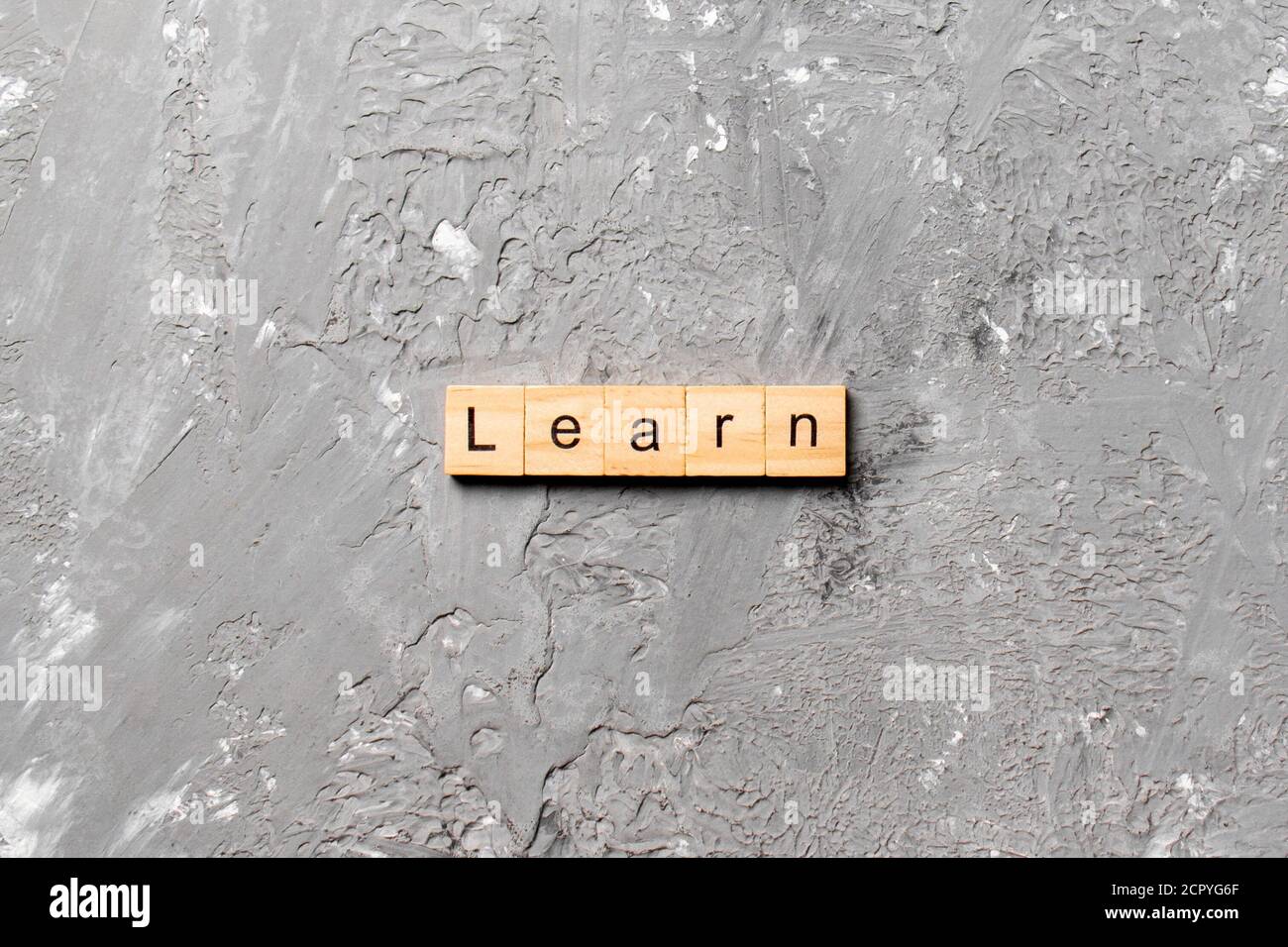 LEARN word written on wood block. LEARN text on cement table for your ...